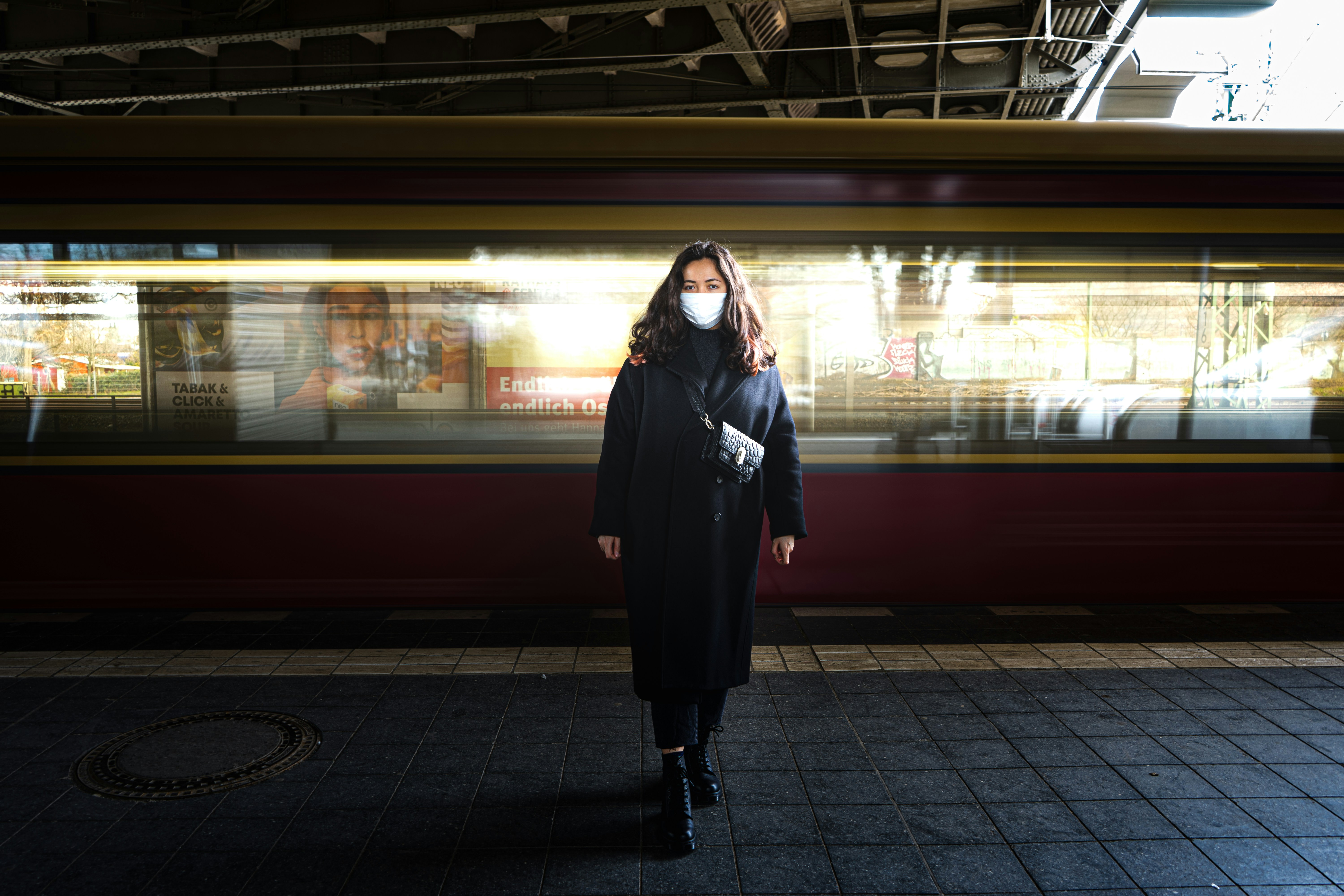 Still Center: A Masked Figure Stands as a Train Whips By