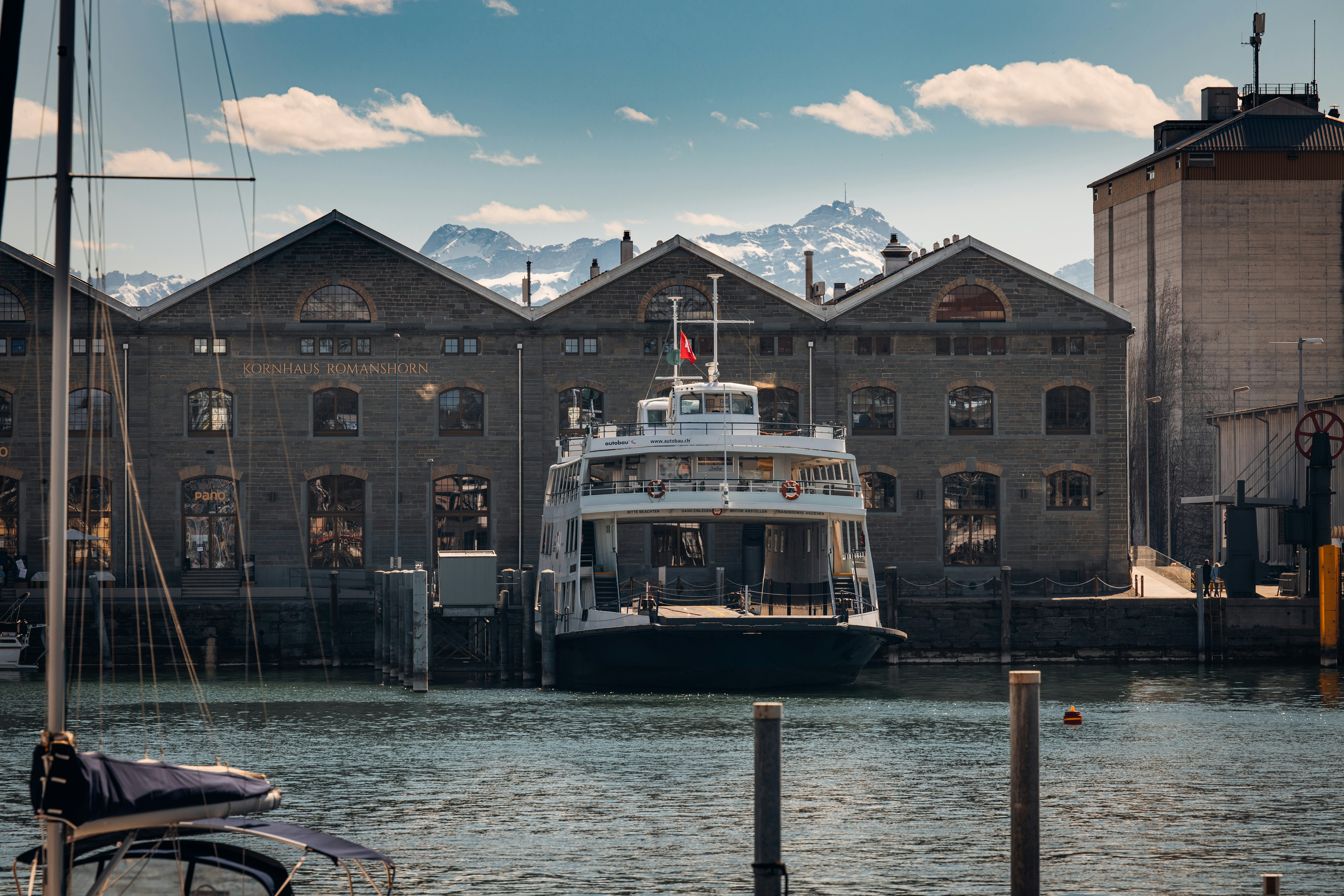 Docked Ferry Framed by Brick Warehouses and Alpine Peaks