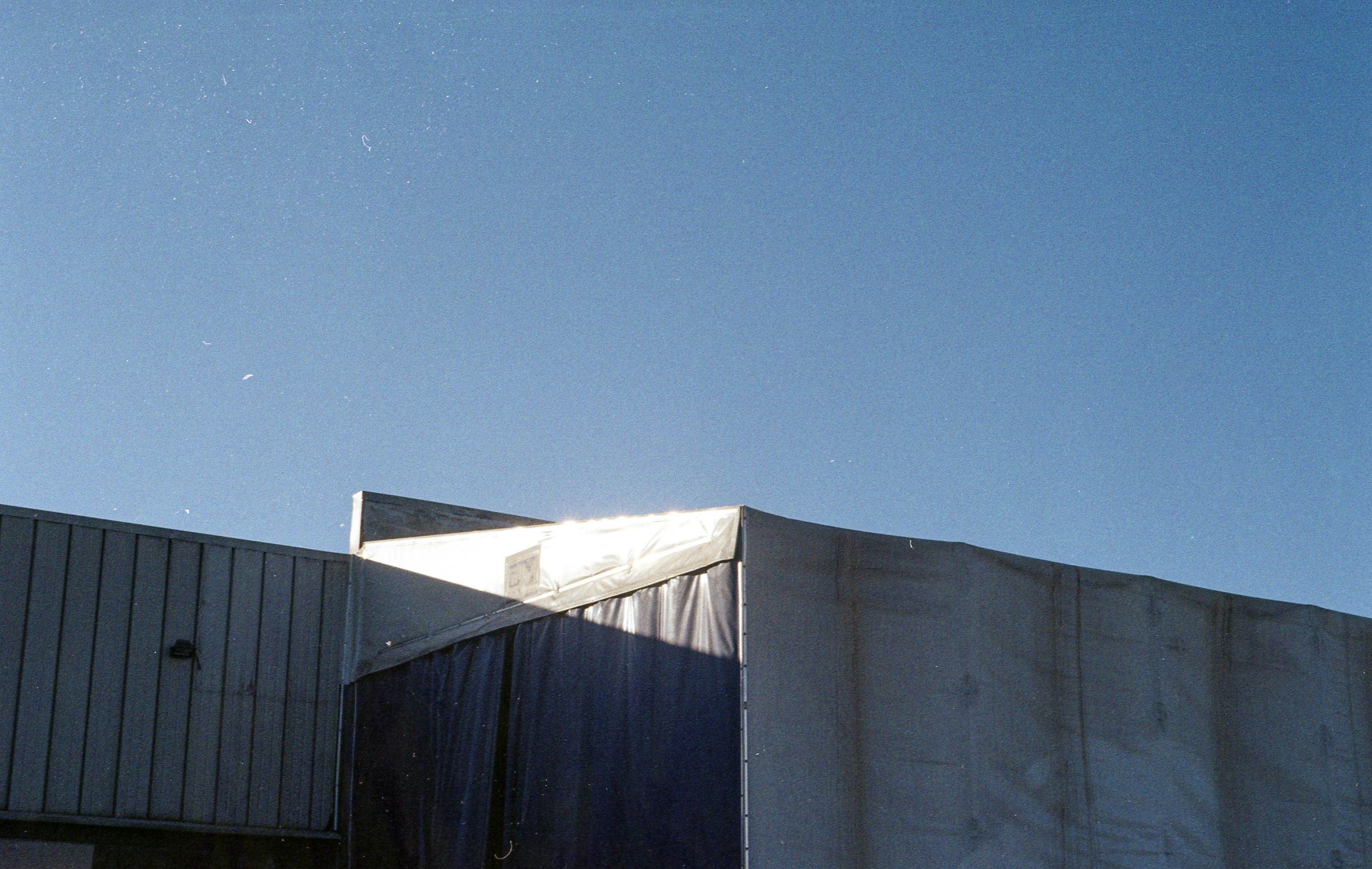 Tarped Ridge Under a Clear Industrial Sky