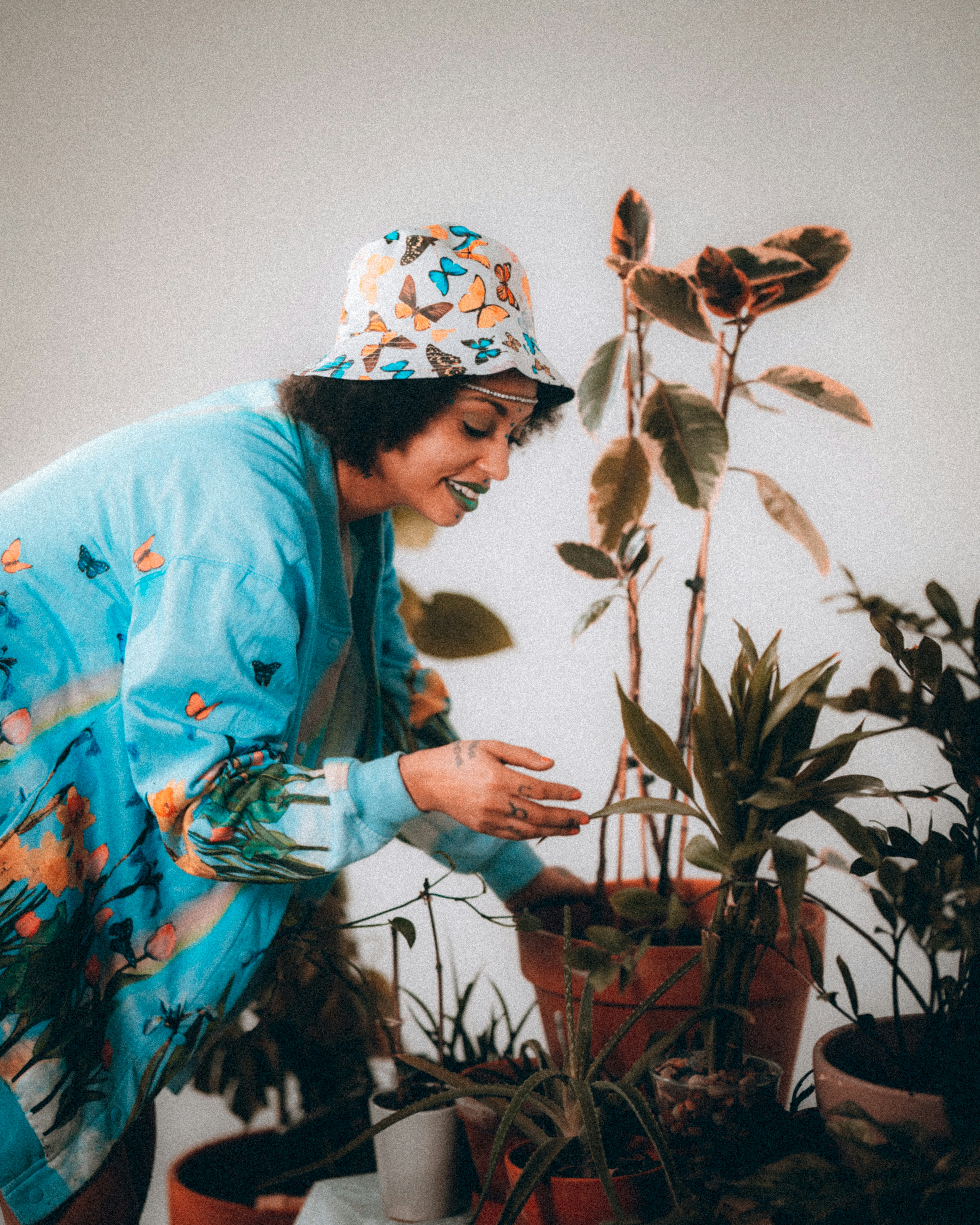 woman in blue and white floral hijab standing near green plant