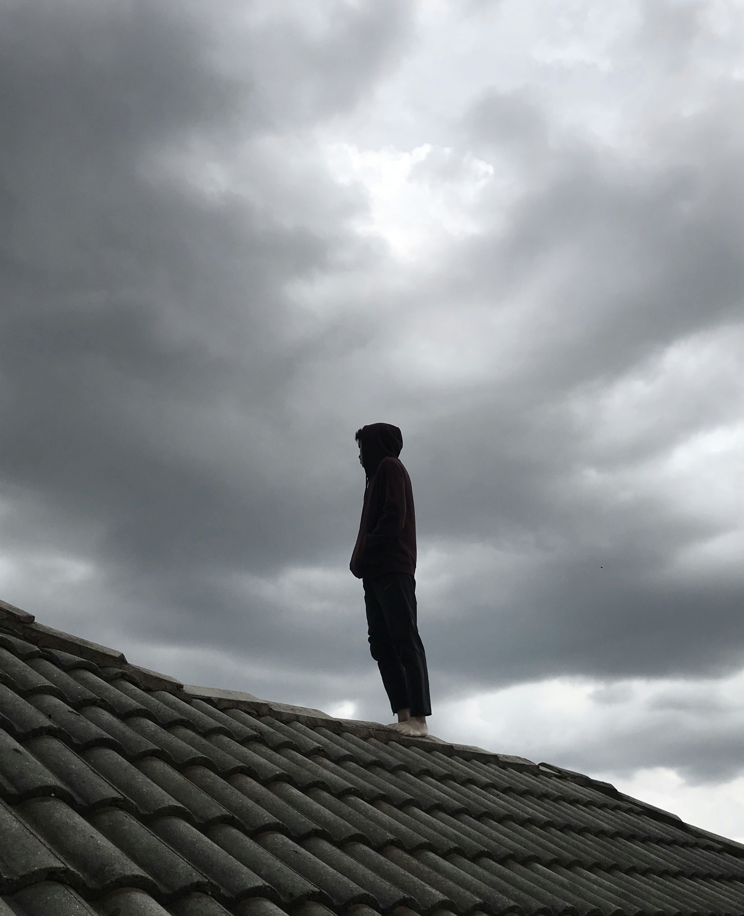 낮에 지붕에 서 있는 검은 재킷을 입은 남자 사진 – Unsplash의 무료 회색 이미지