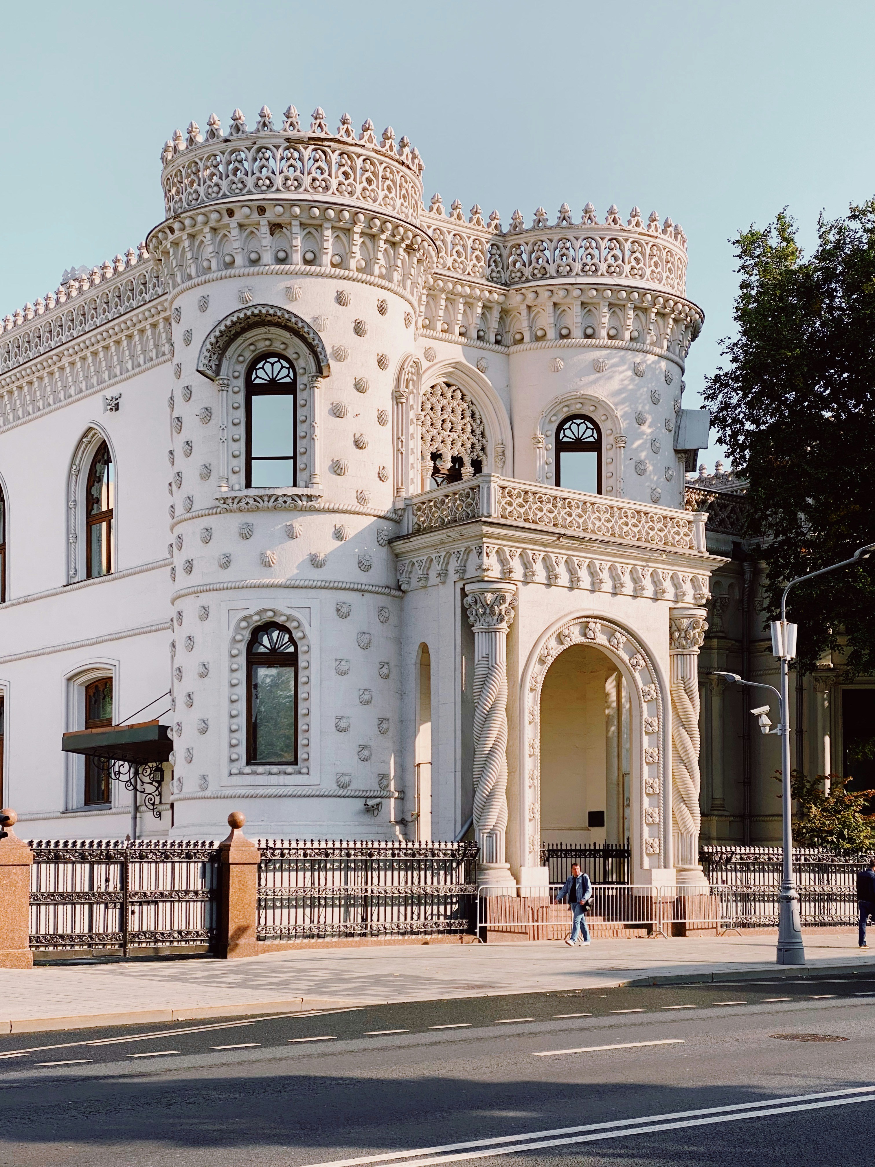 Circles and Arches: A Turreted White Facade on the Boulevard