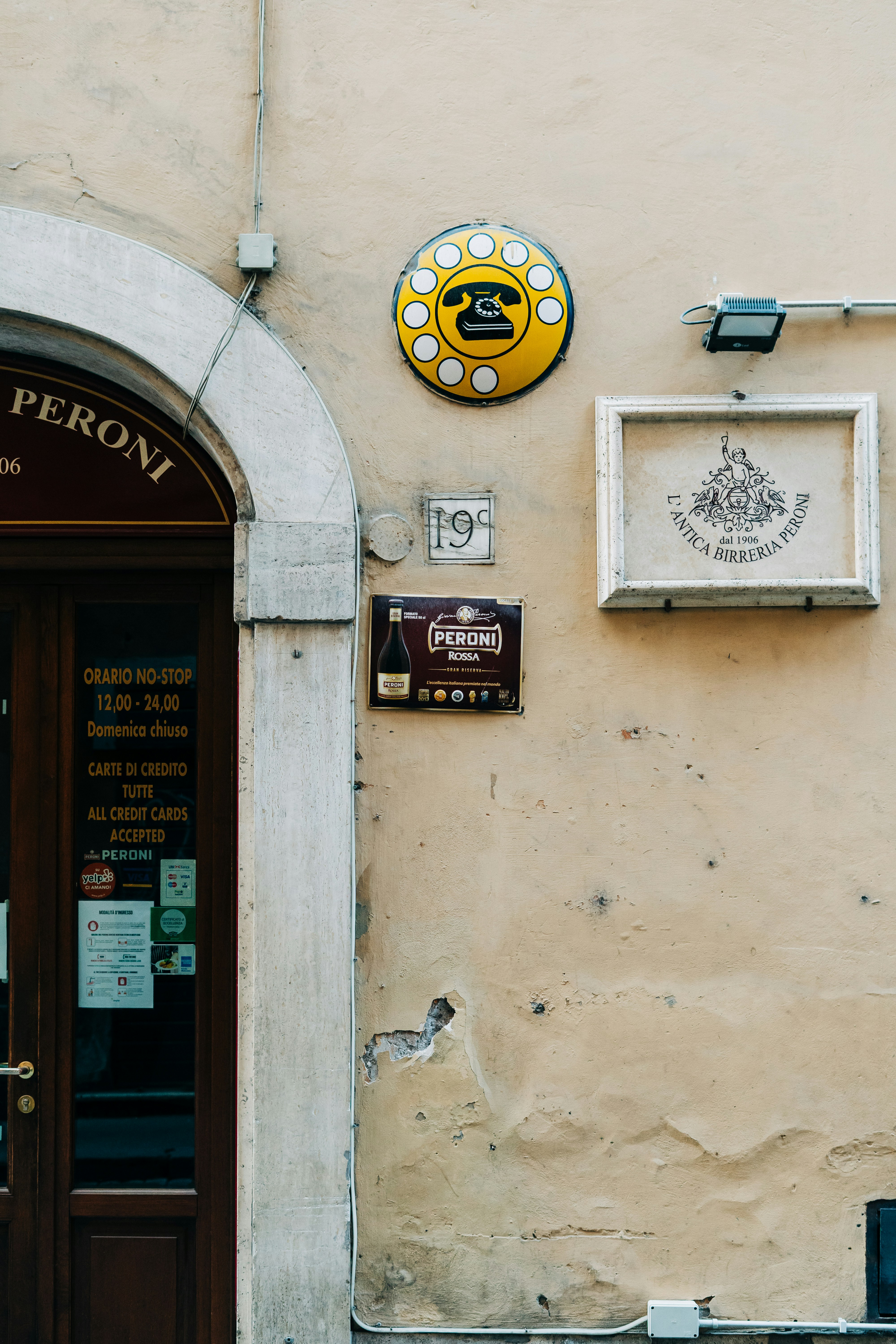 Vintage Yellow Circle Sign Anchoring a Weathered Italian Façade
