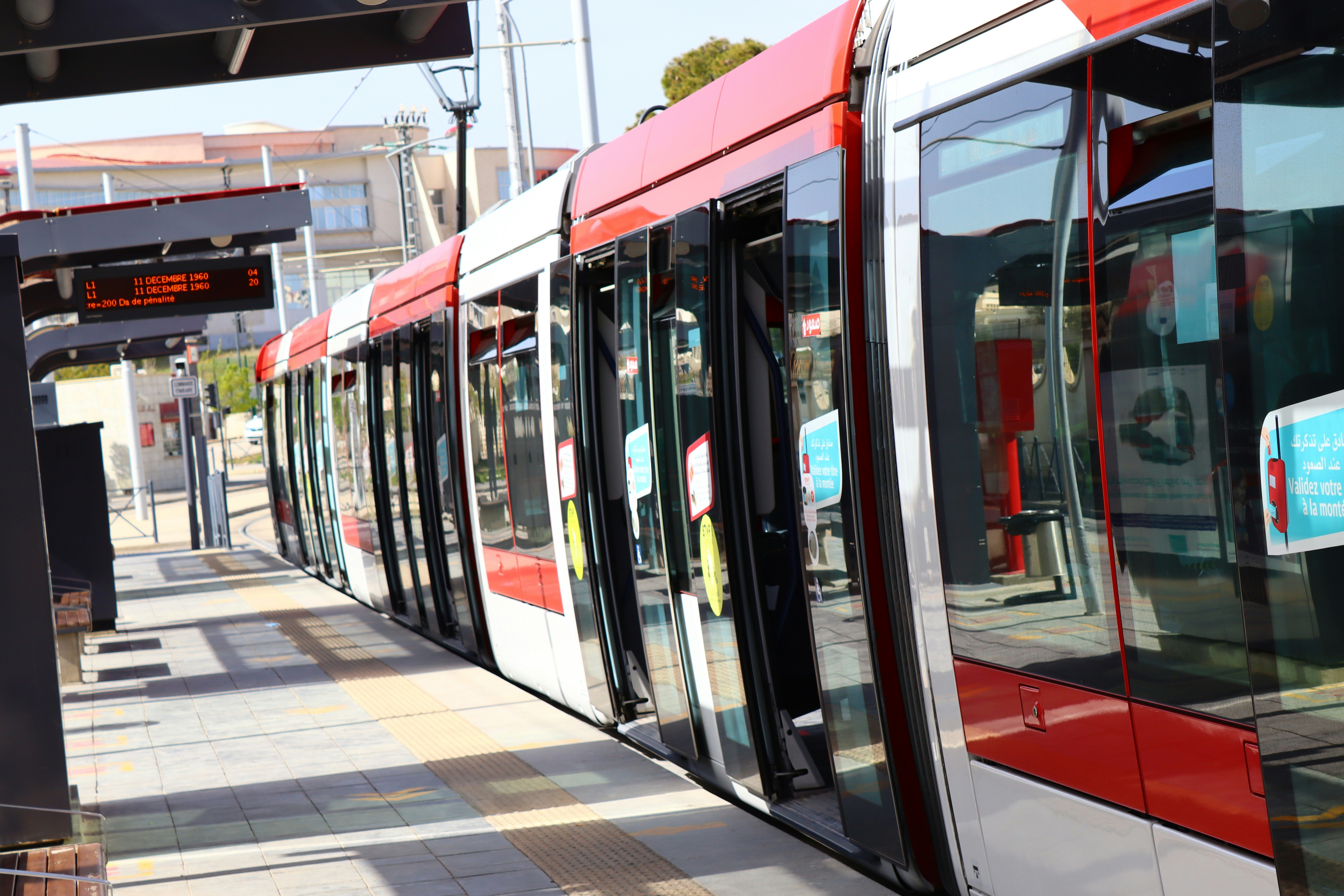 A sleek tram awaits passengers at a bustling station, showcasing urban transportation's efficiency and design.