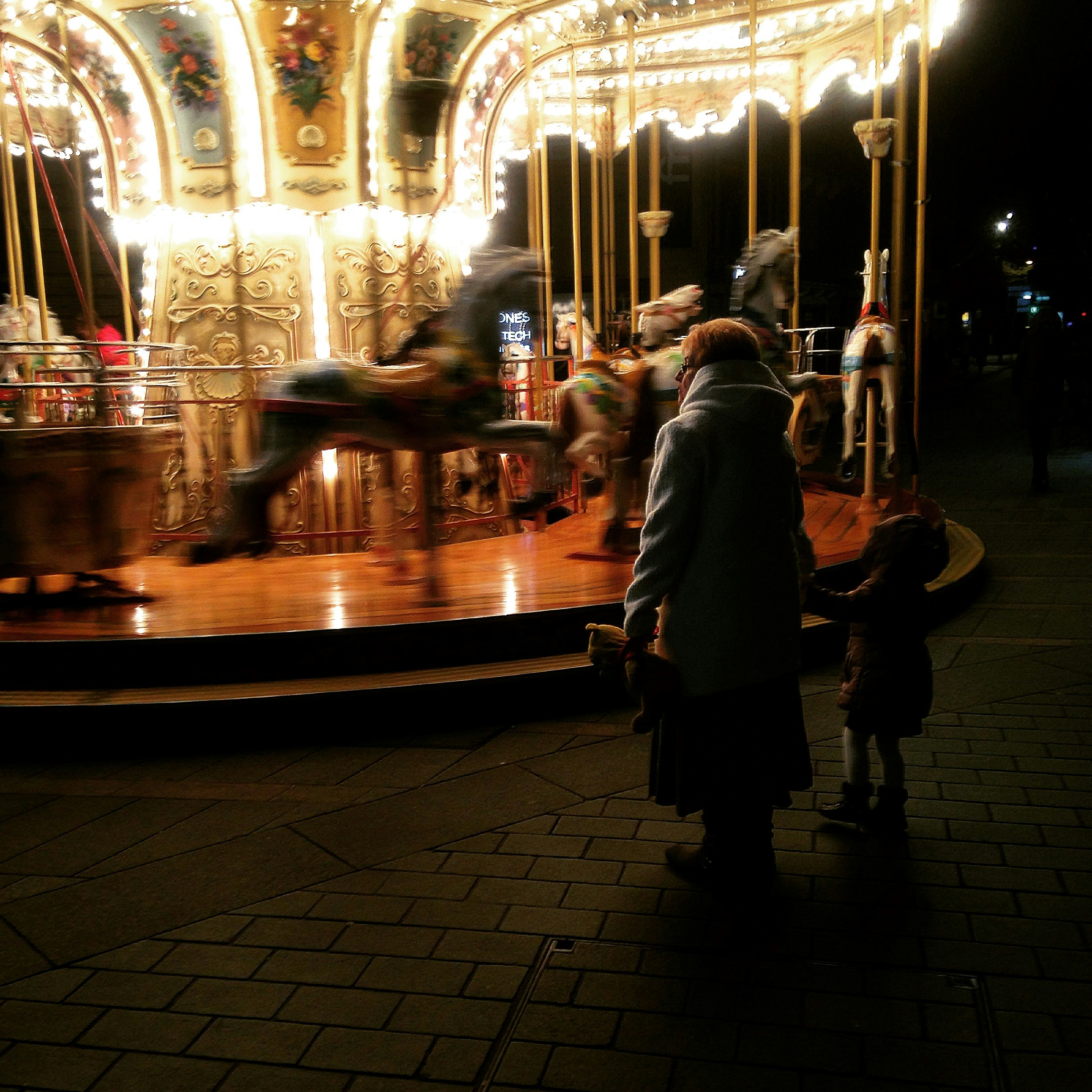 Twilight Carousel: A Mother and Child in the Warm Glow