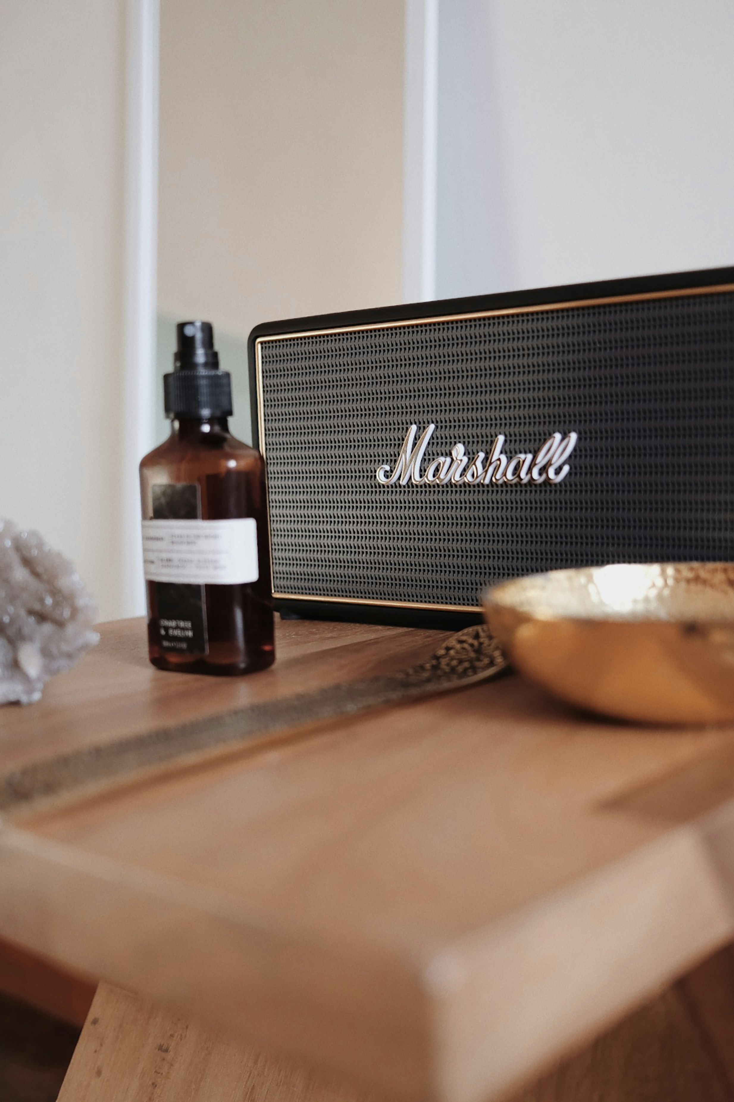 Warm Vinyl Echoes: A Marshall Speaker and Aromatic Bottles on a Wooden Desk