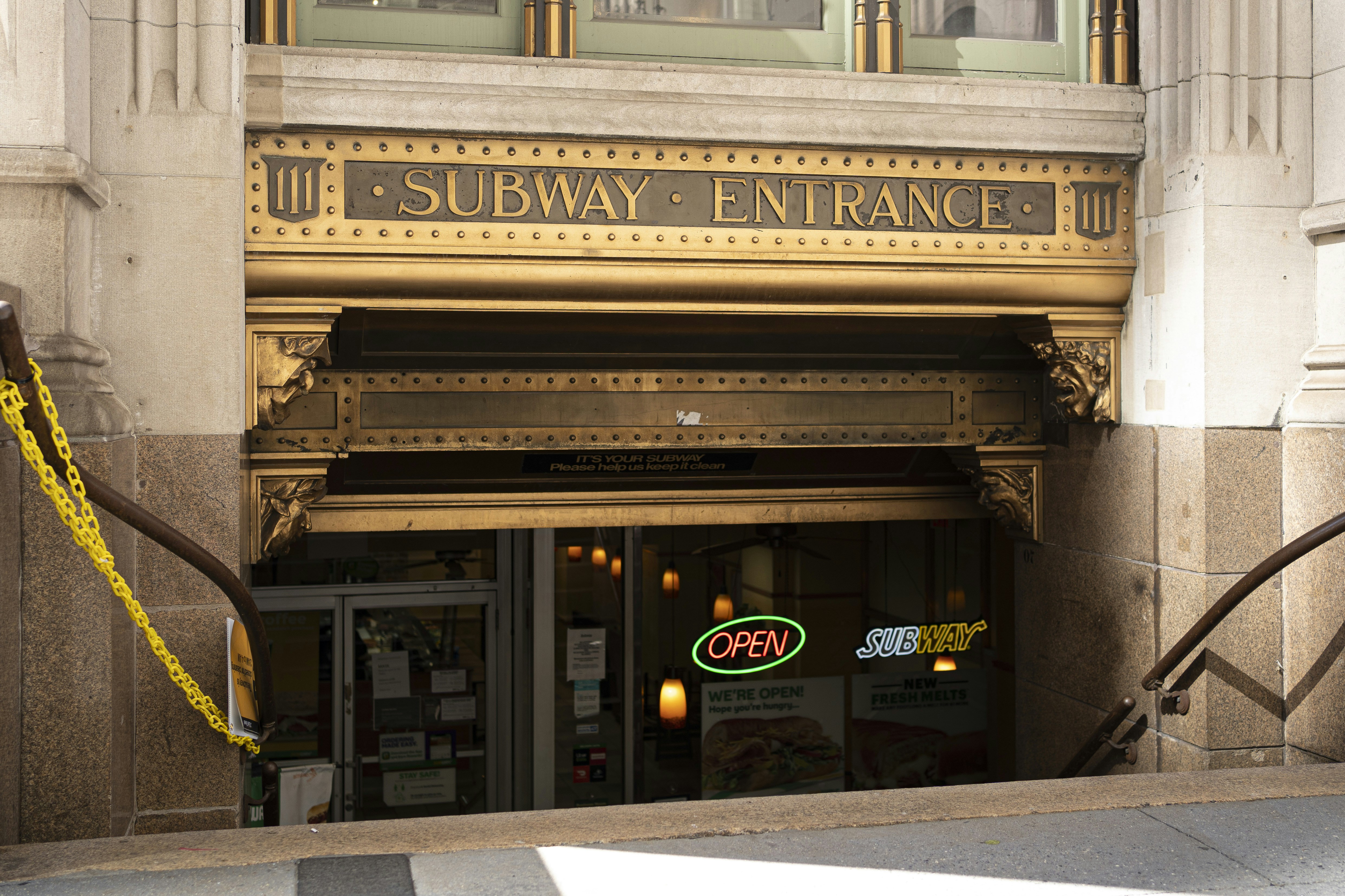Underground Threshold: The Subway Entrance Beneath Ornate Signage