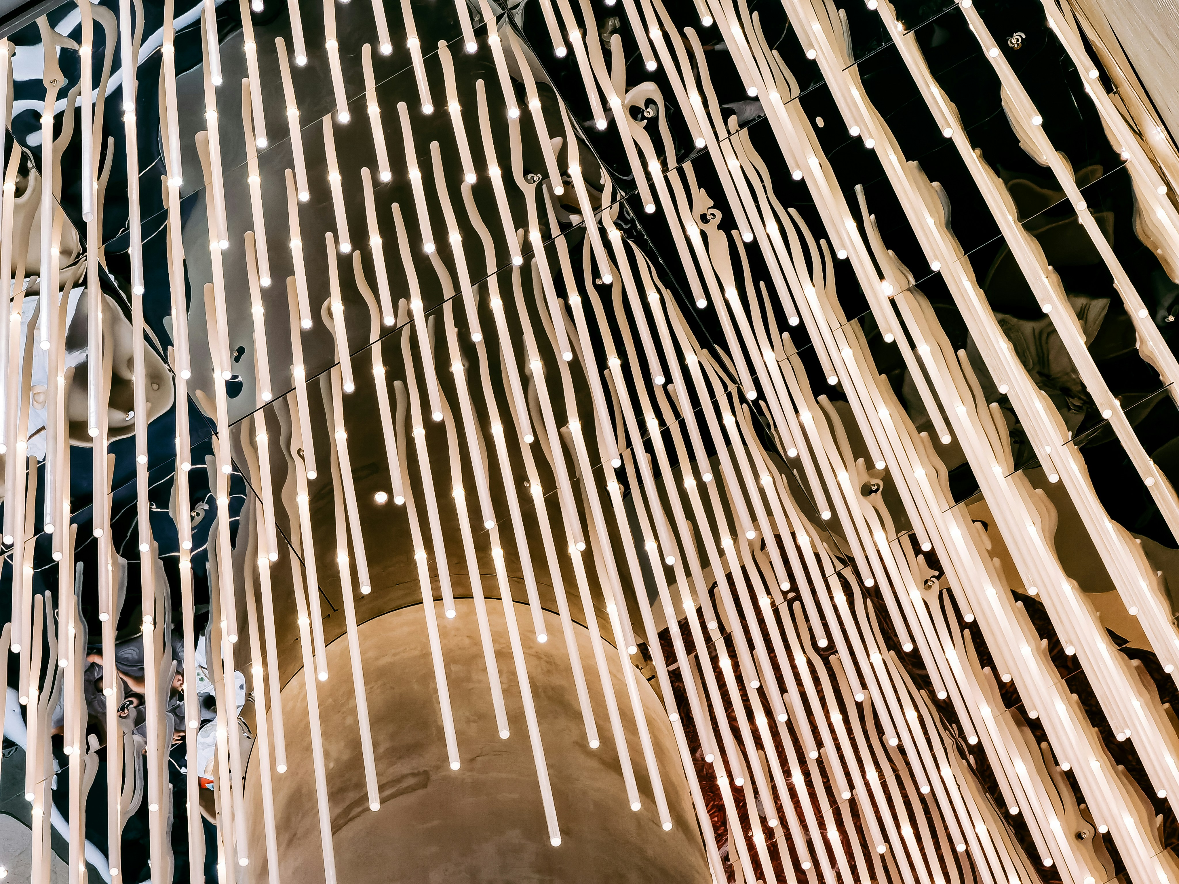 Abstract arrangement of hanging light fixtures creating a dynamic visual flow in a contemporary space.