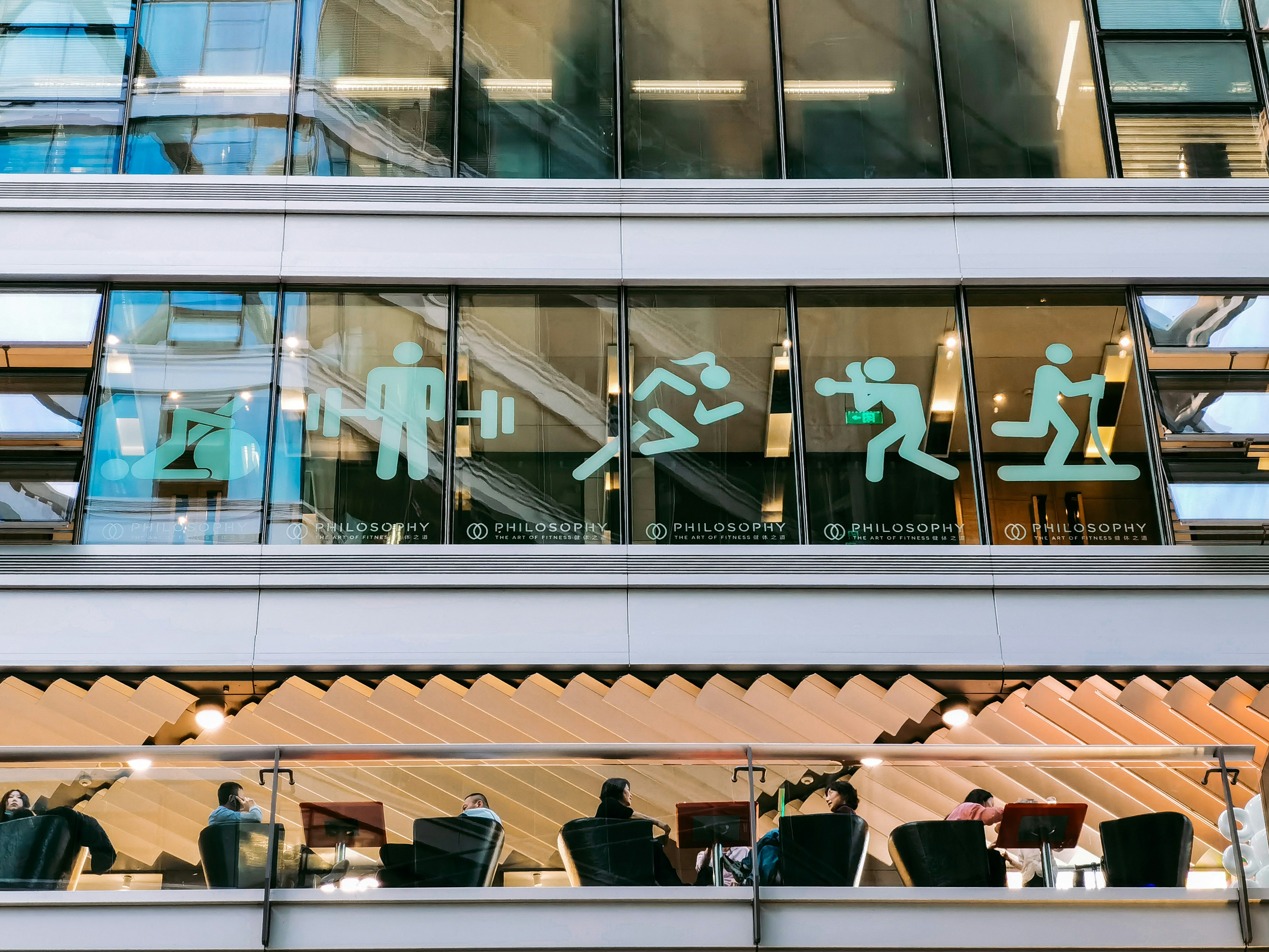 Azure Figures on a Glass Facade: A Quiet Urban Interior Slice