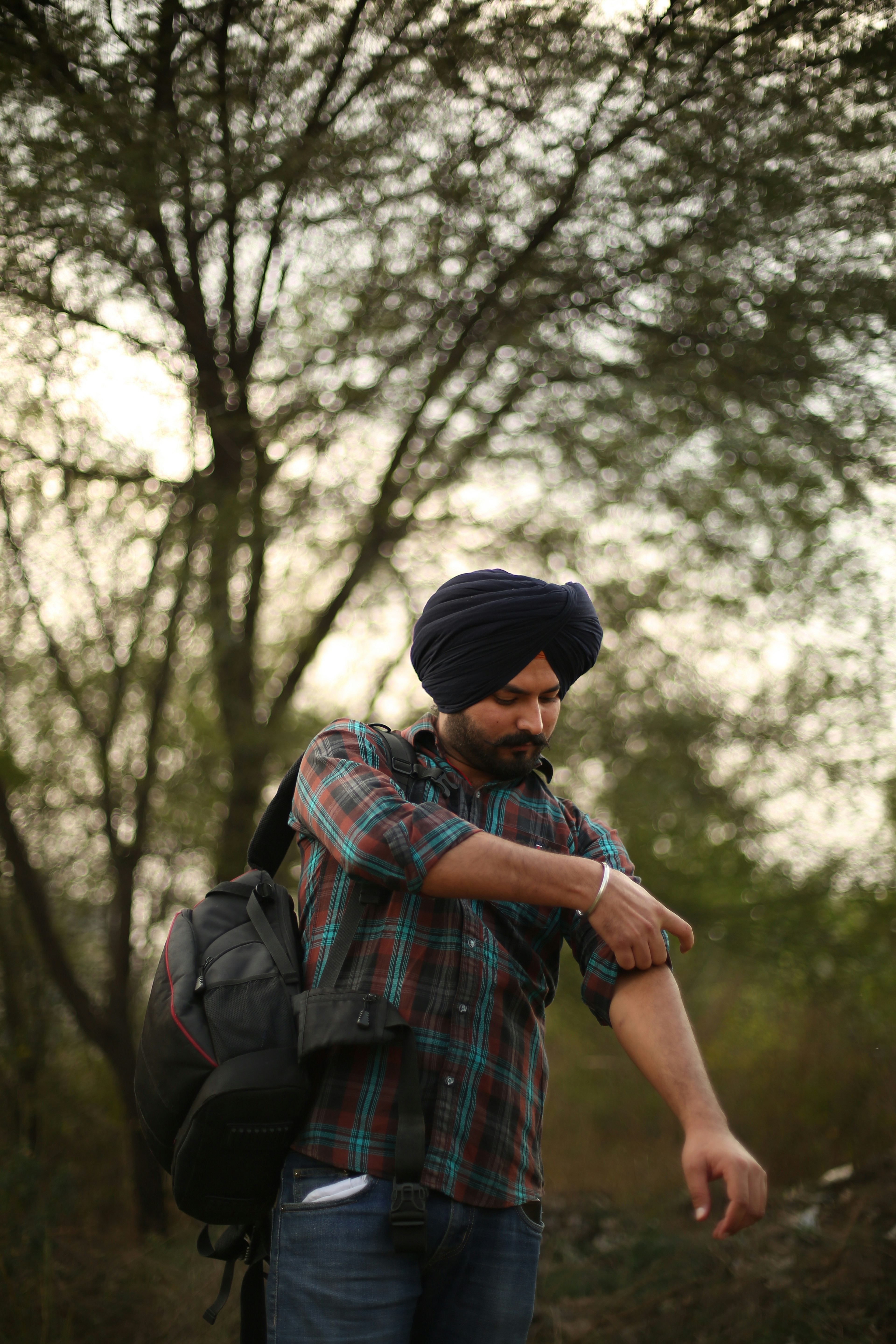 Man in black cap and plaid shirt standing near trees during daytime ...