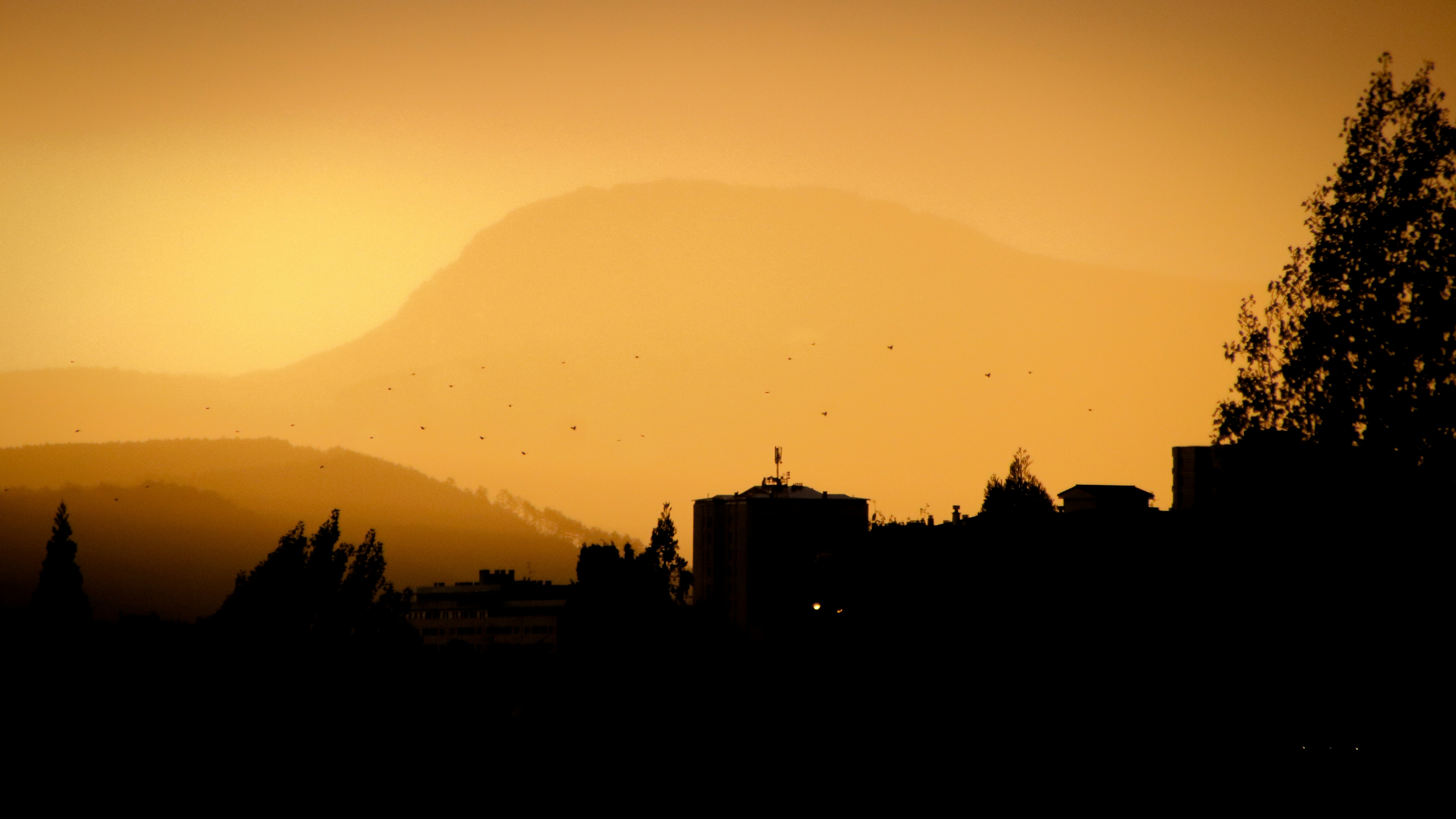 Dusk Over the City: A Distant Mountain Casts a Quiet Glow