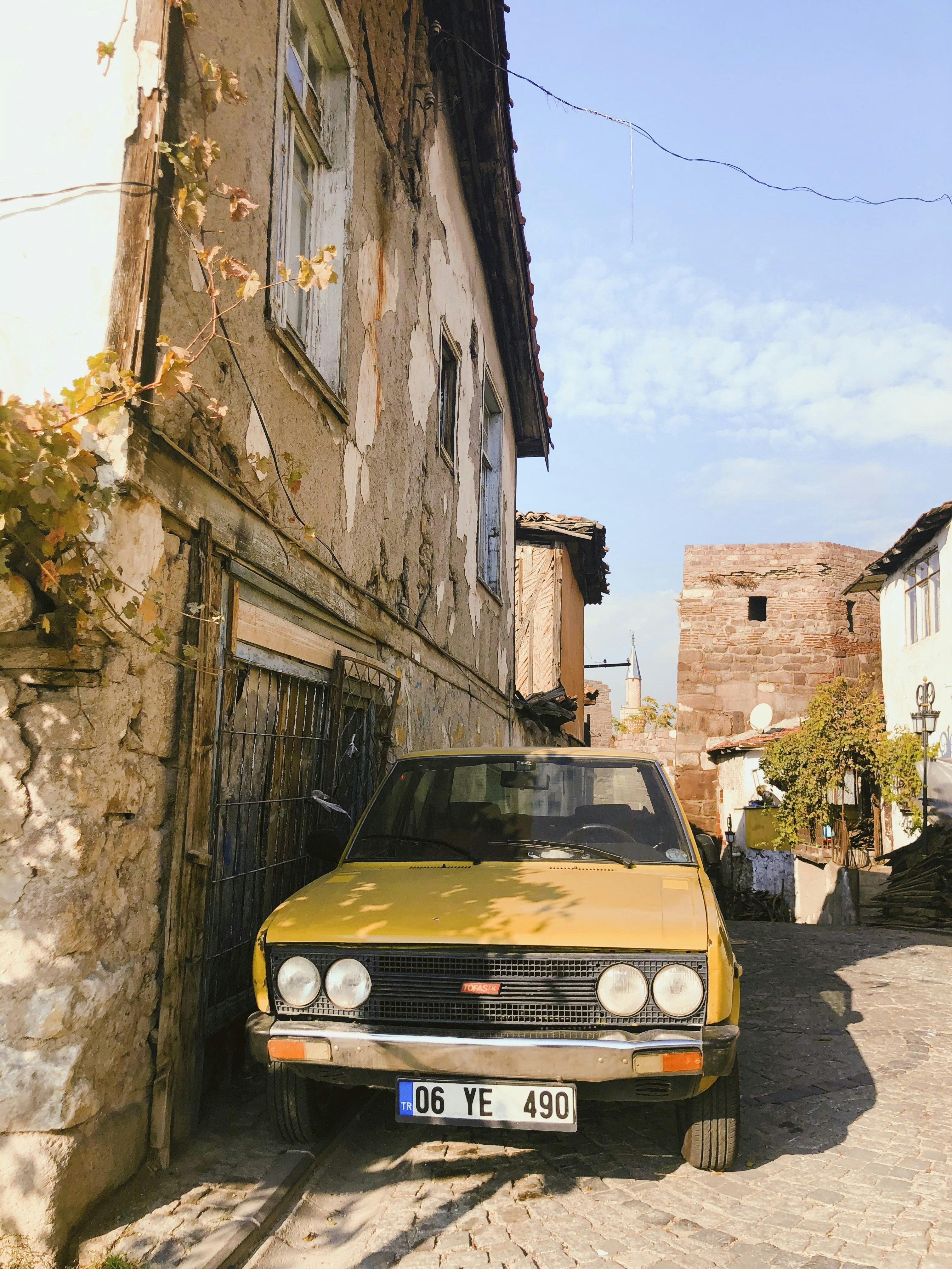 Yellow Sedan in Narrow Cobblestone Street