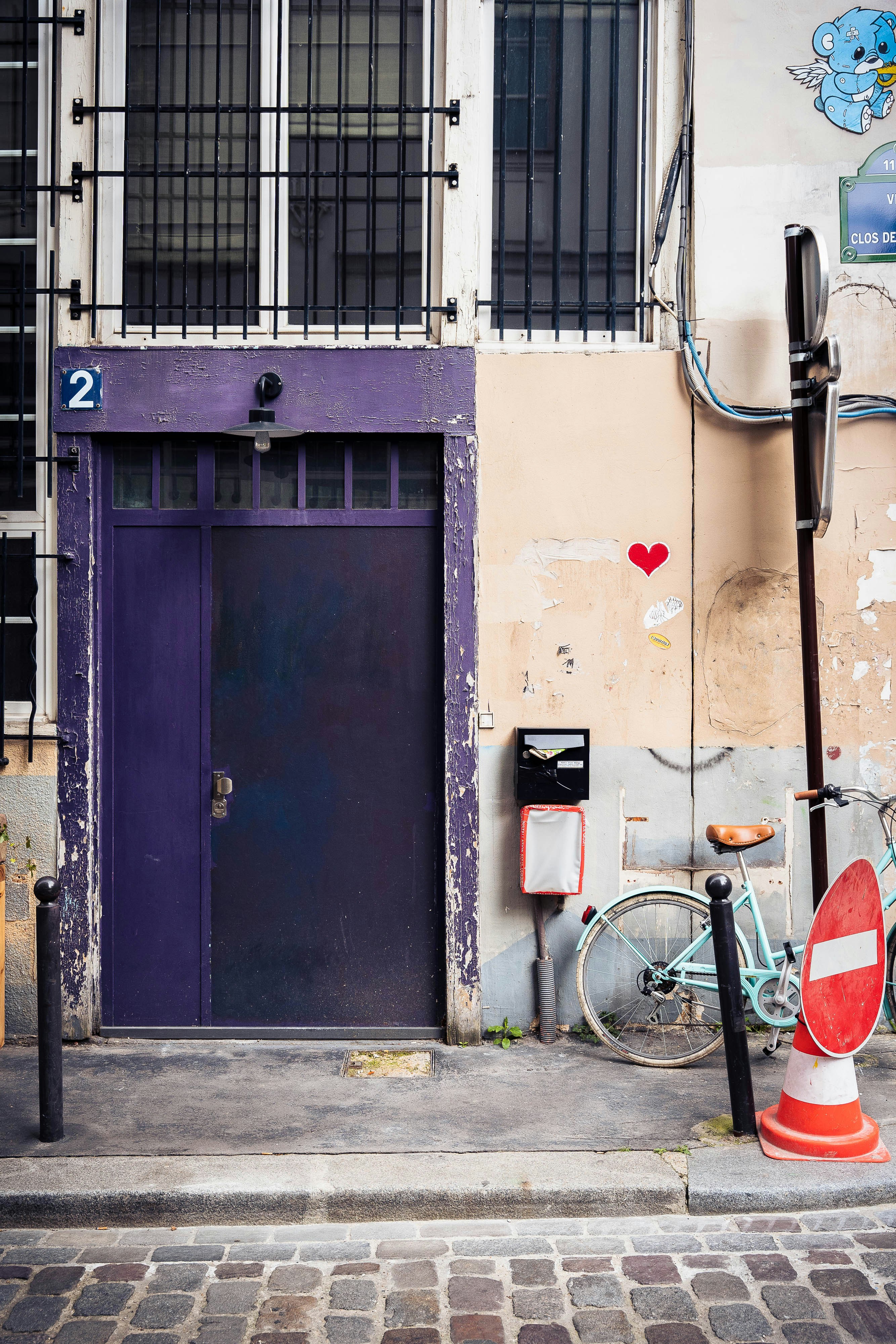 Purple Door on a Worn Facade: A Quiet European Street with a Bicycle