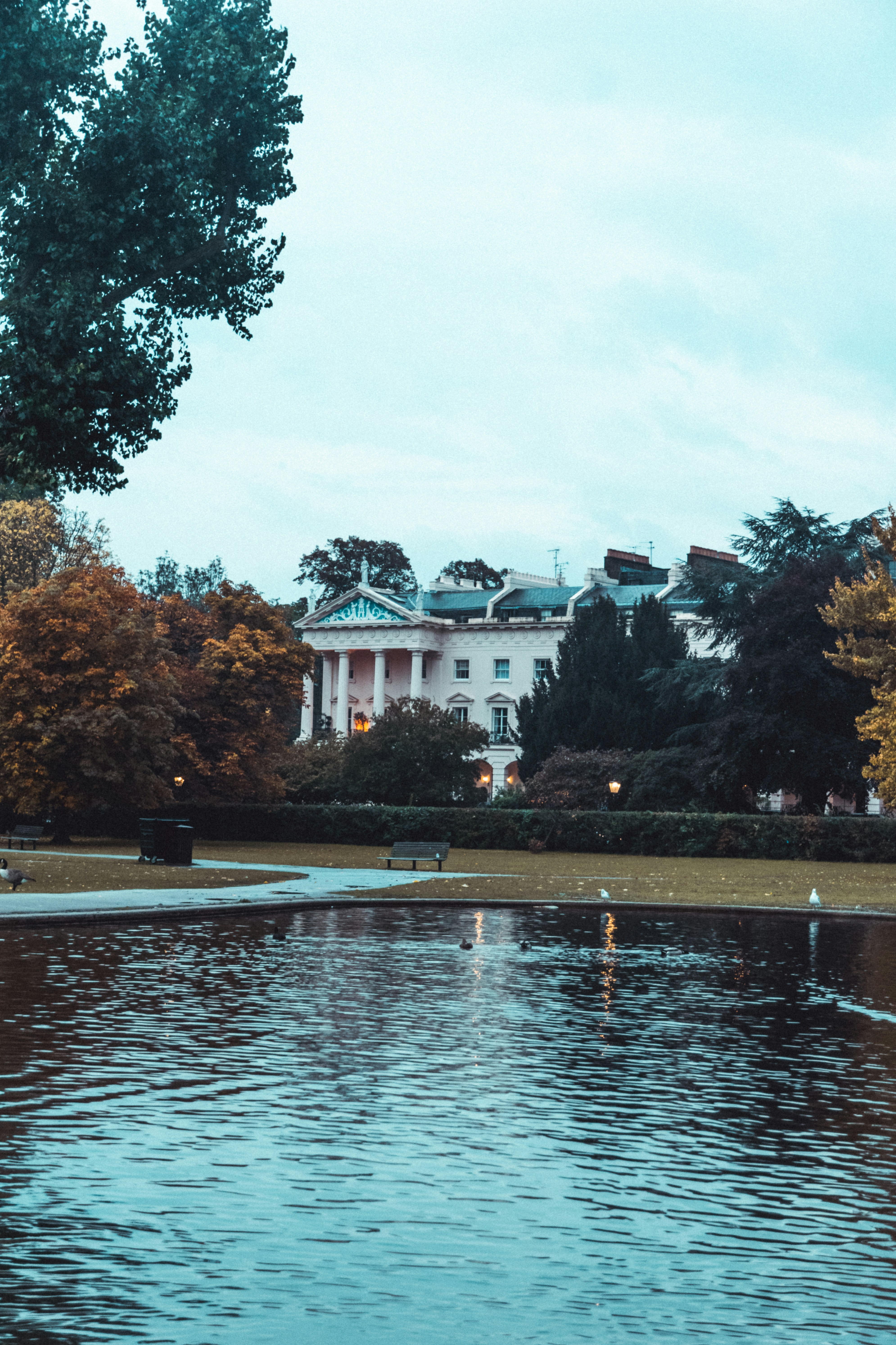 Ivory Manor Rising Behind Autumn-Colored Trees Over a Quiet Pond