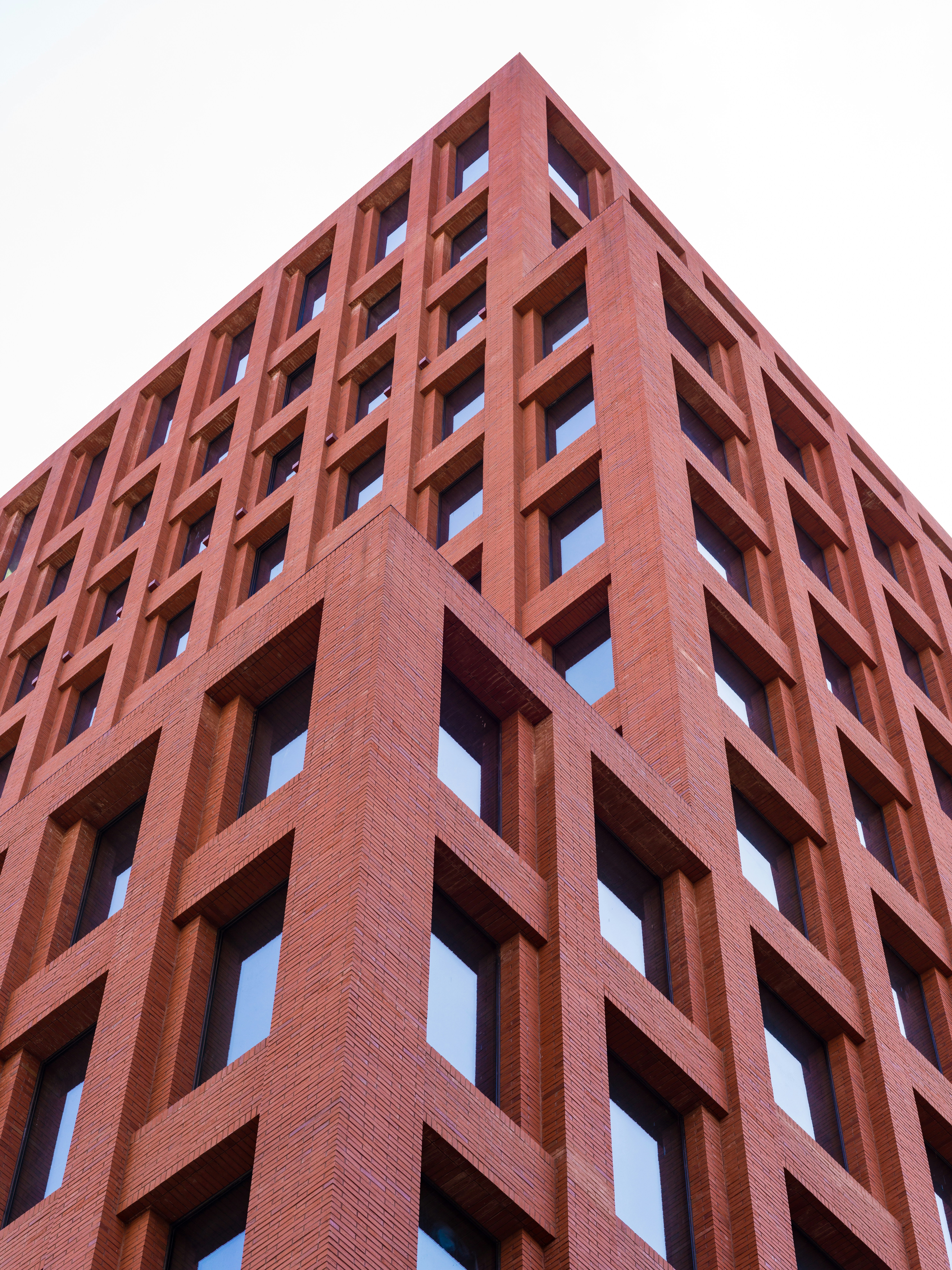 Angular view of a modern red brick building showcasing its intricate window patterns and geometric design.