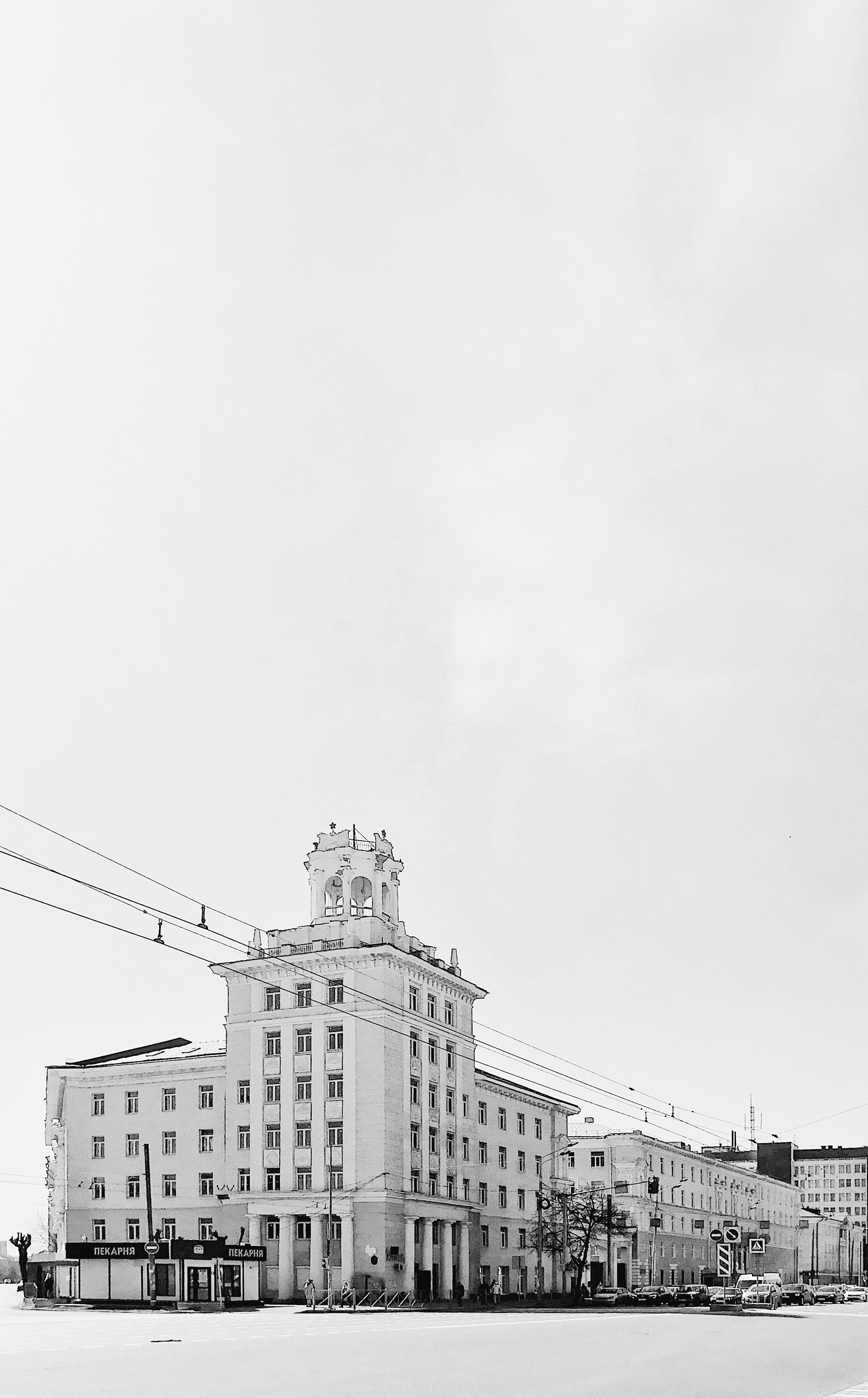 Historic building with intricate architectural details stands prominently against a clear sky, showcasing urban design elements. Black and white composition enhances its timeless appeal.