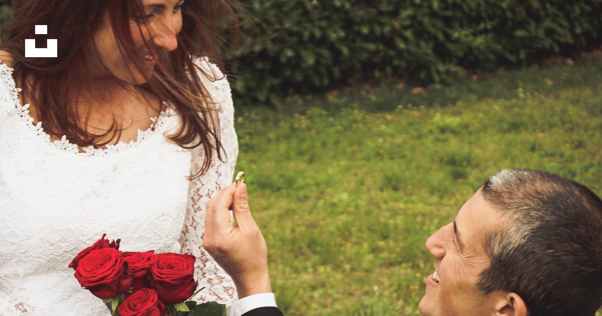 Woman In White Wedding Dress Holding Red Rose Bouquet Photo Free