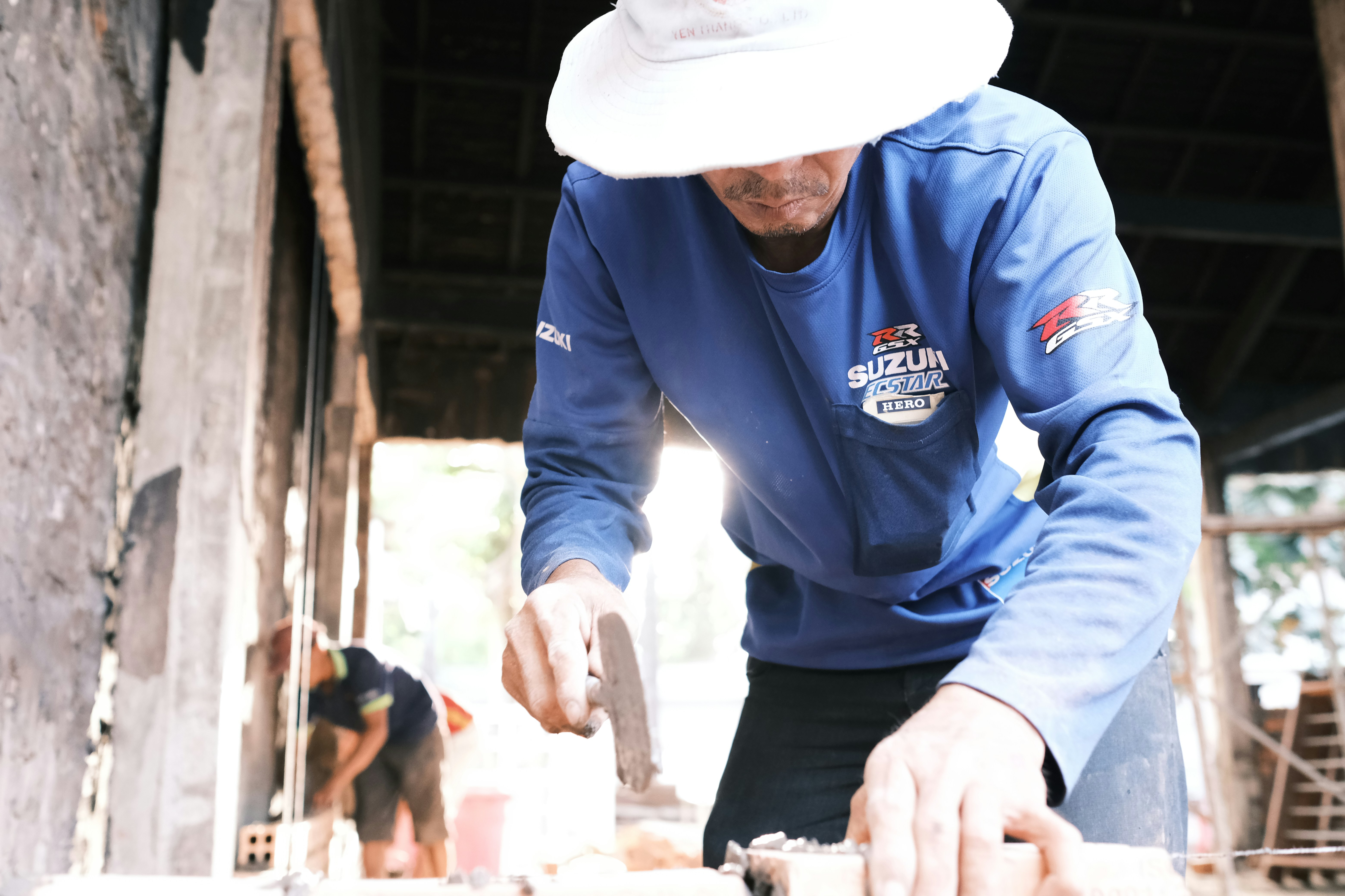A skilled worker meticulously shaping materials in a construction site, showcasing dedication and craftsmanship.