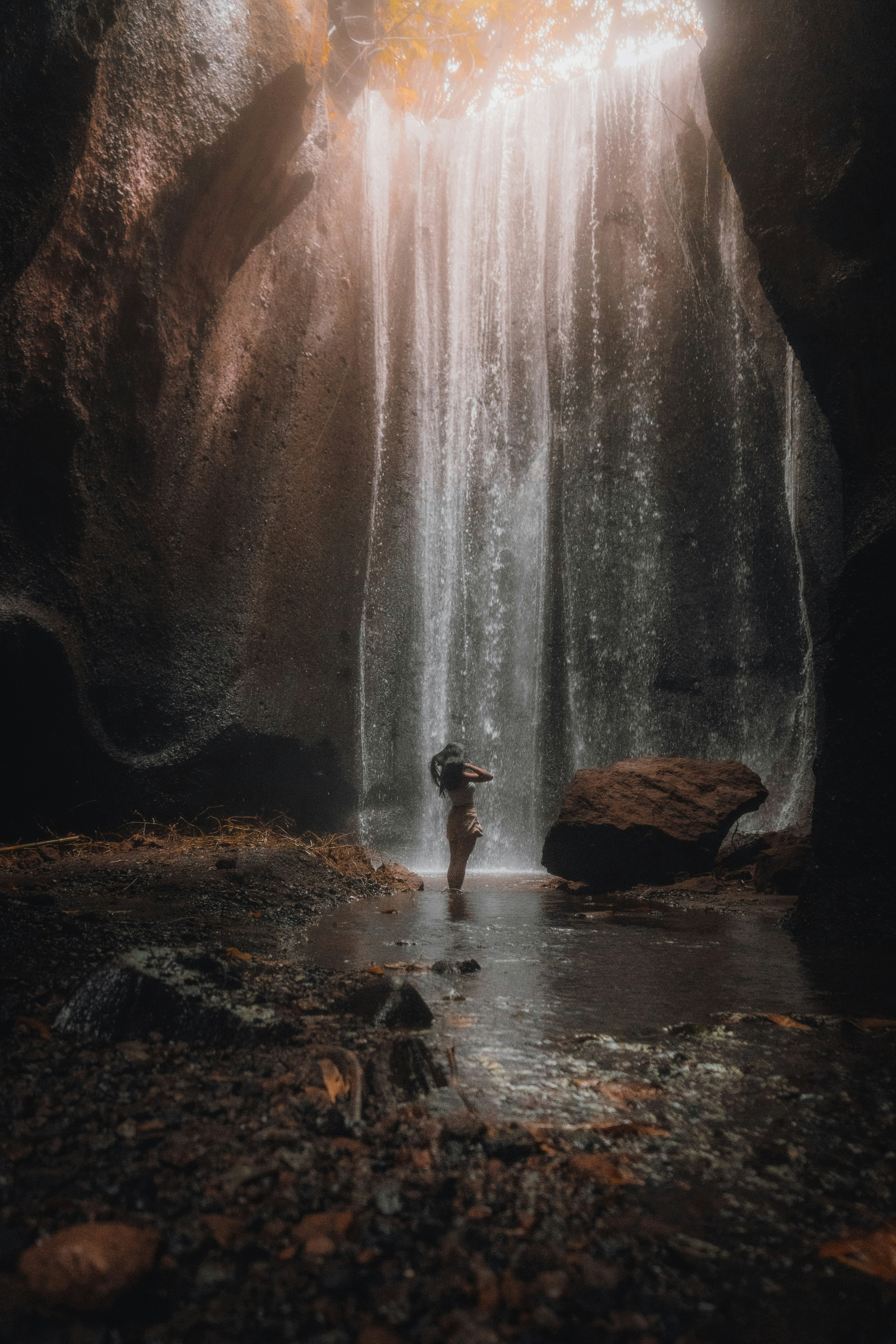 Person standing on rock in front of waterfalls photo – Free Bali Image ...