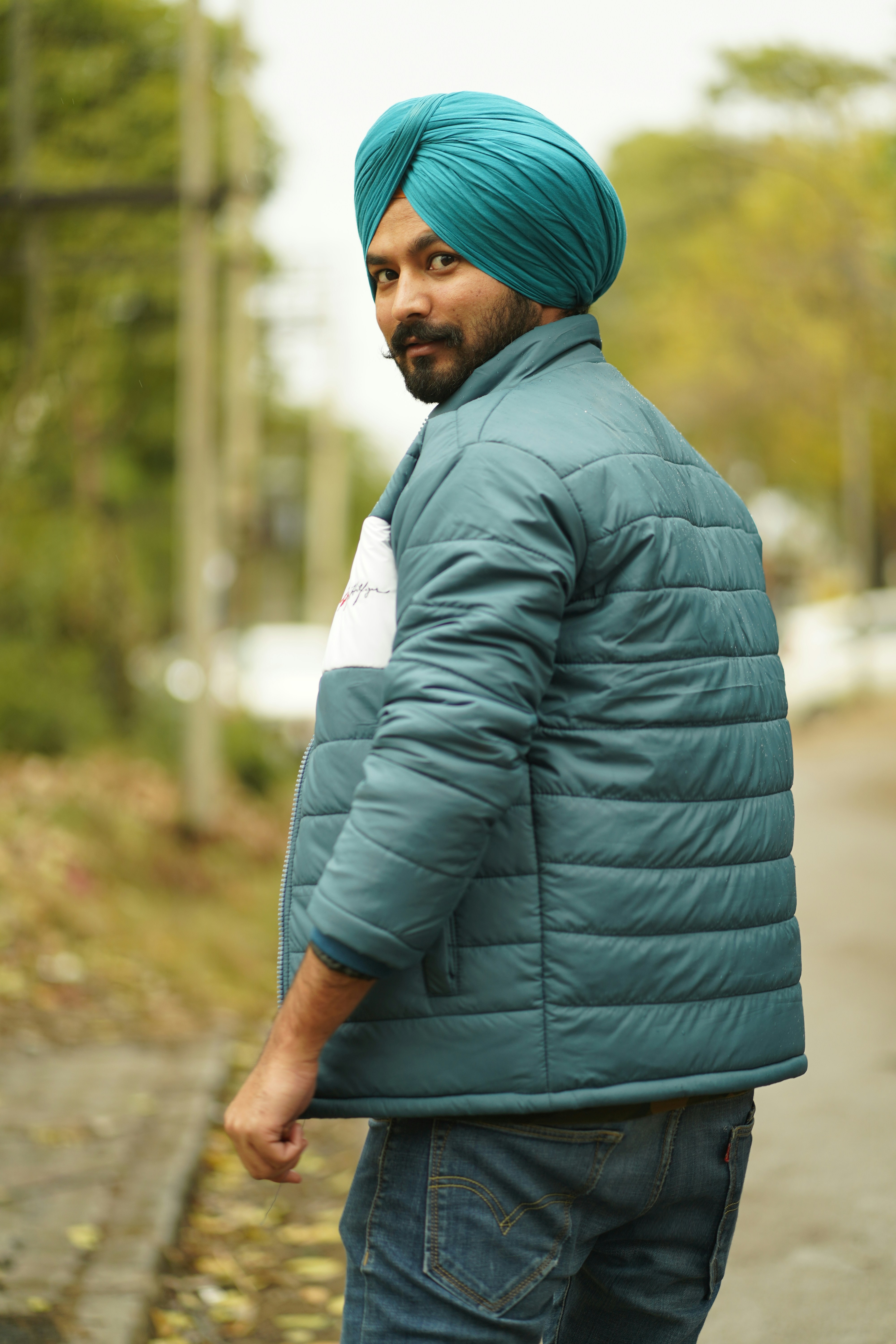 Man in gray long sleeve shirt and blue knit cap standing on road during ...