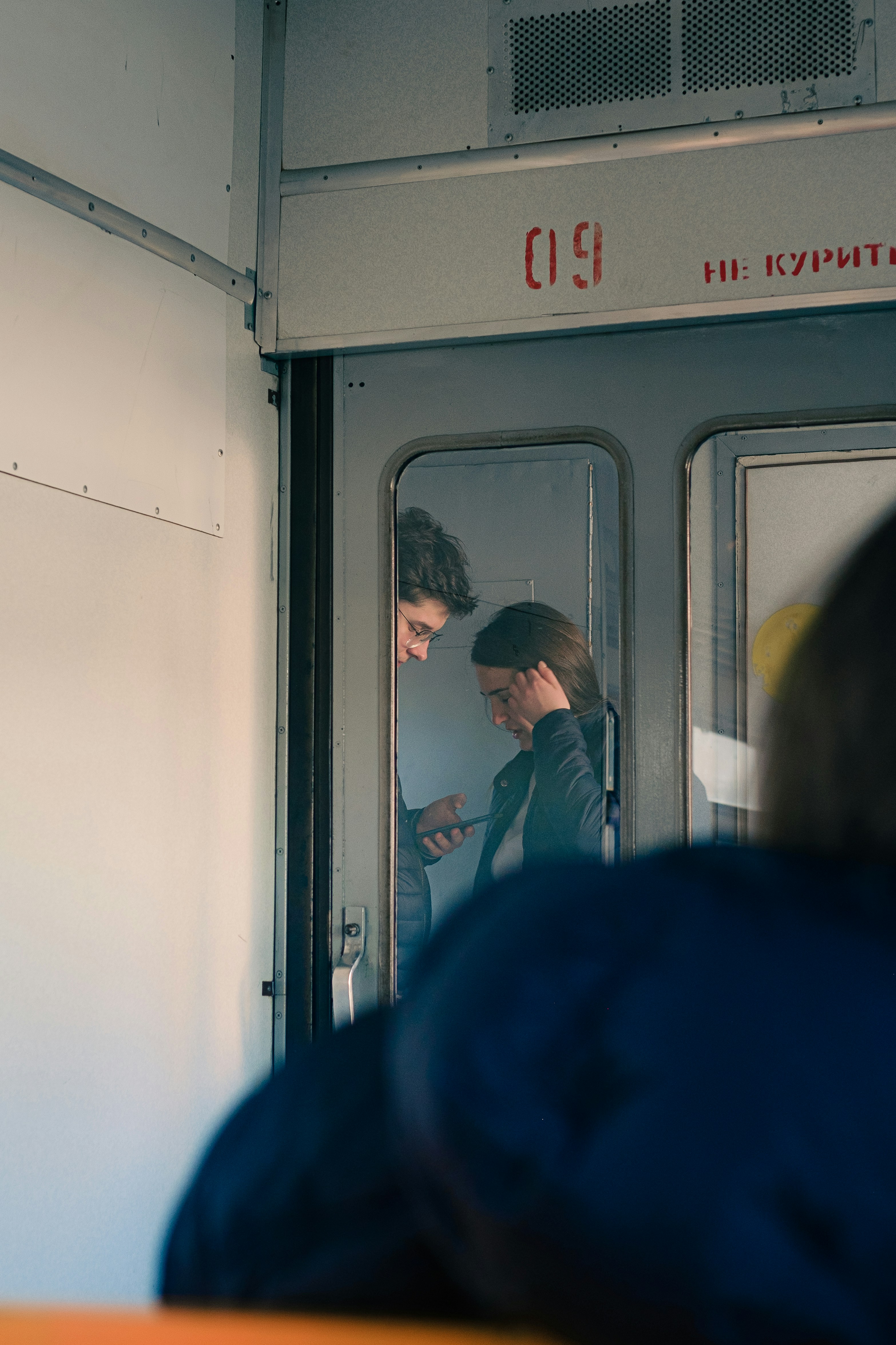 Through the Glass: A Quiet Exchange on a Train Door