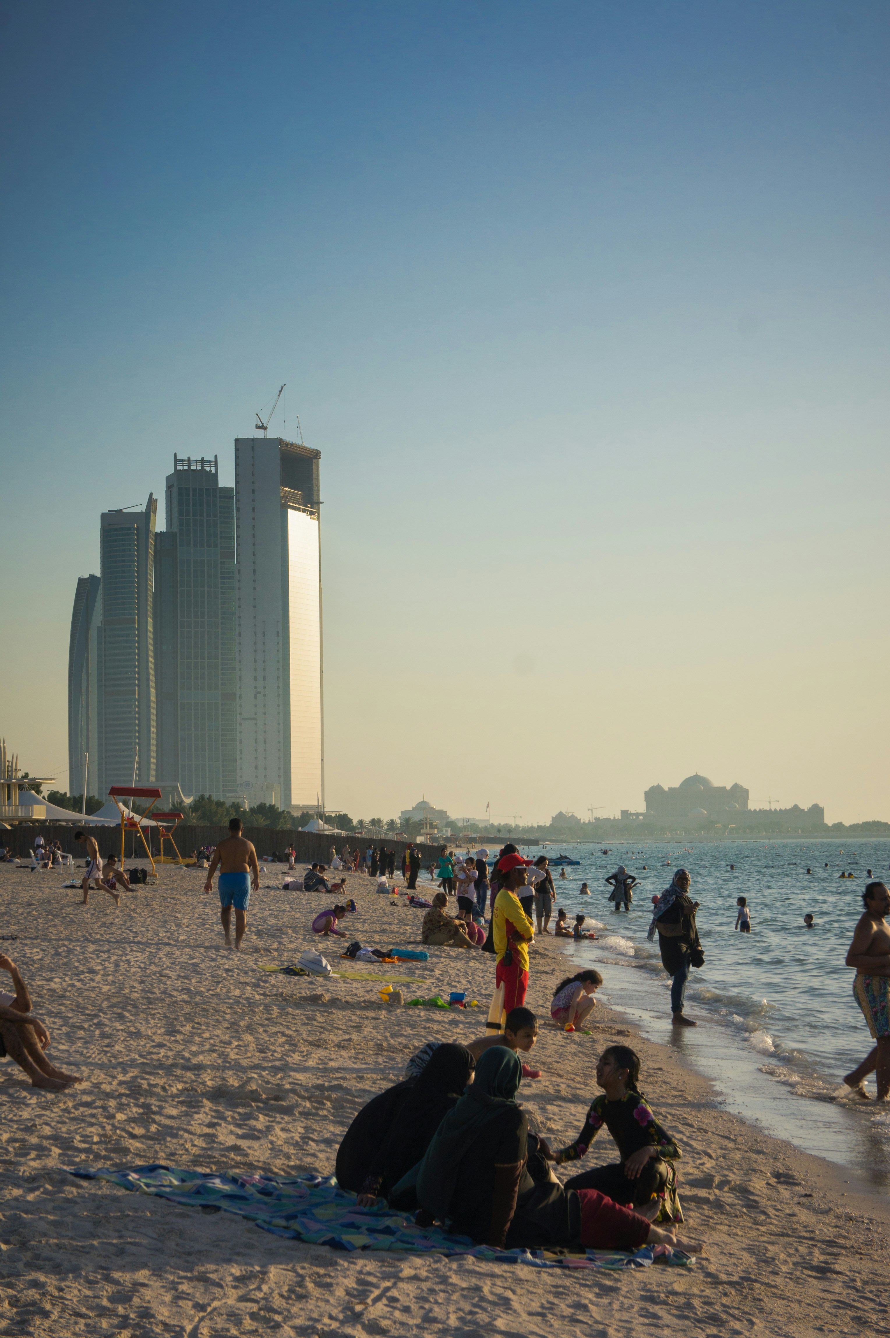 Golden Hour Over the Coast: Glass Towers Rise Above a Lively Beachfront