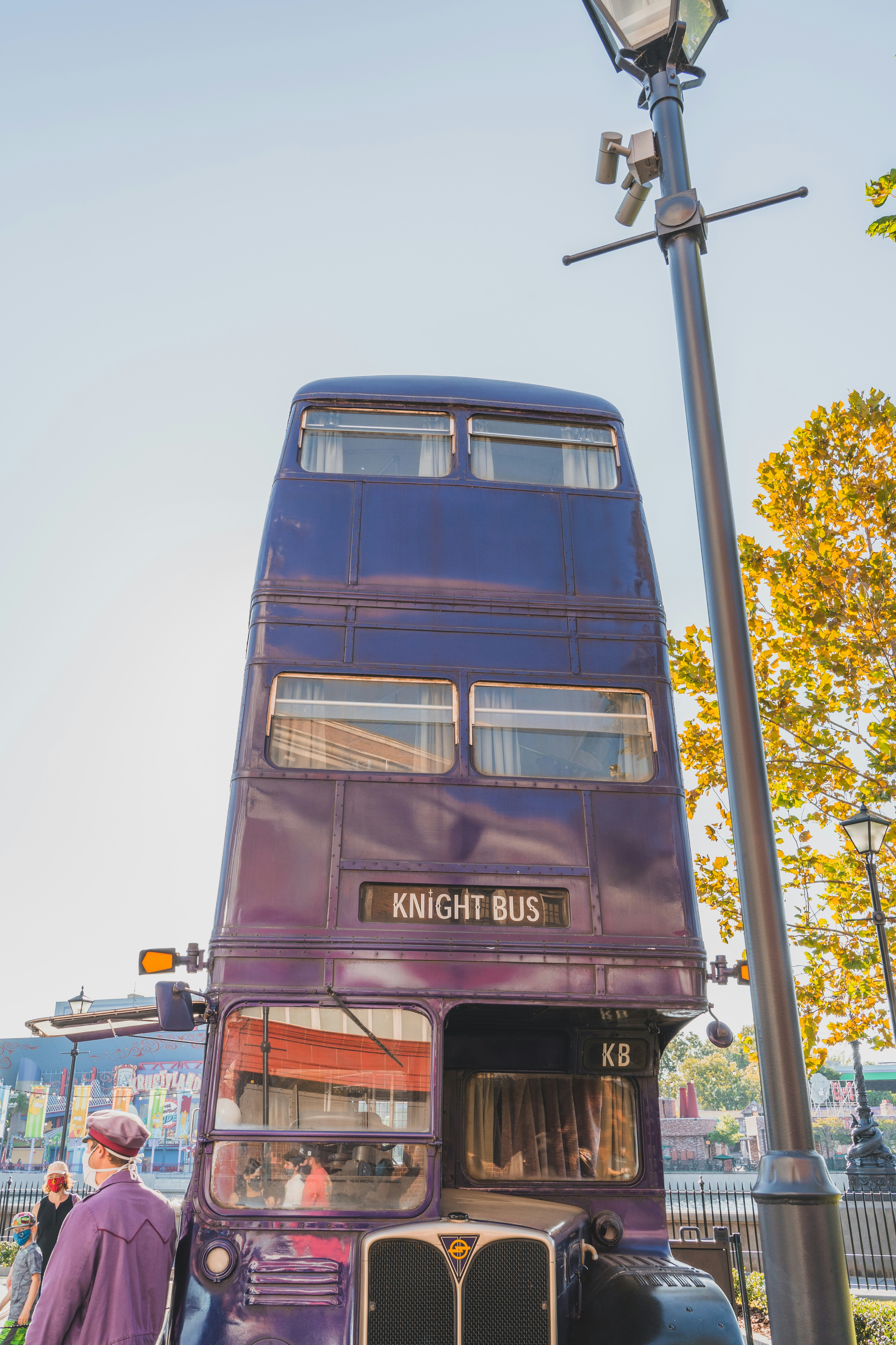 Un bus violet à impériale garé à côté d’un lampadaire photo – Image ...