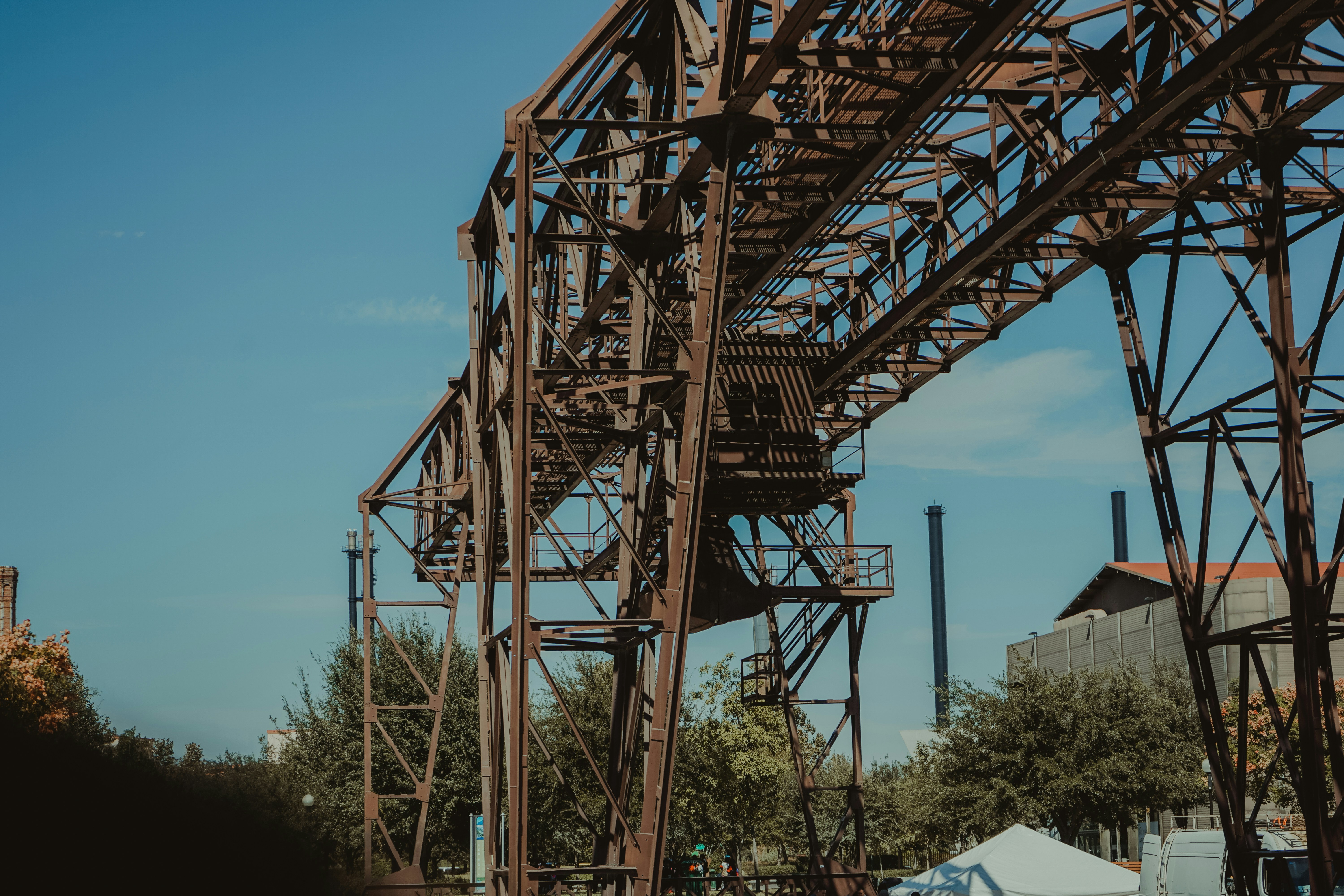 Rustic metal structure with intricate beams set against a vibrant blue sky.