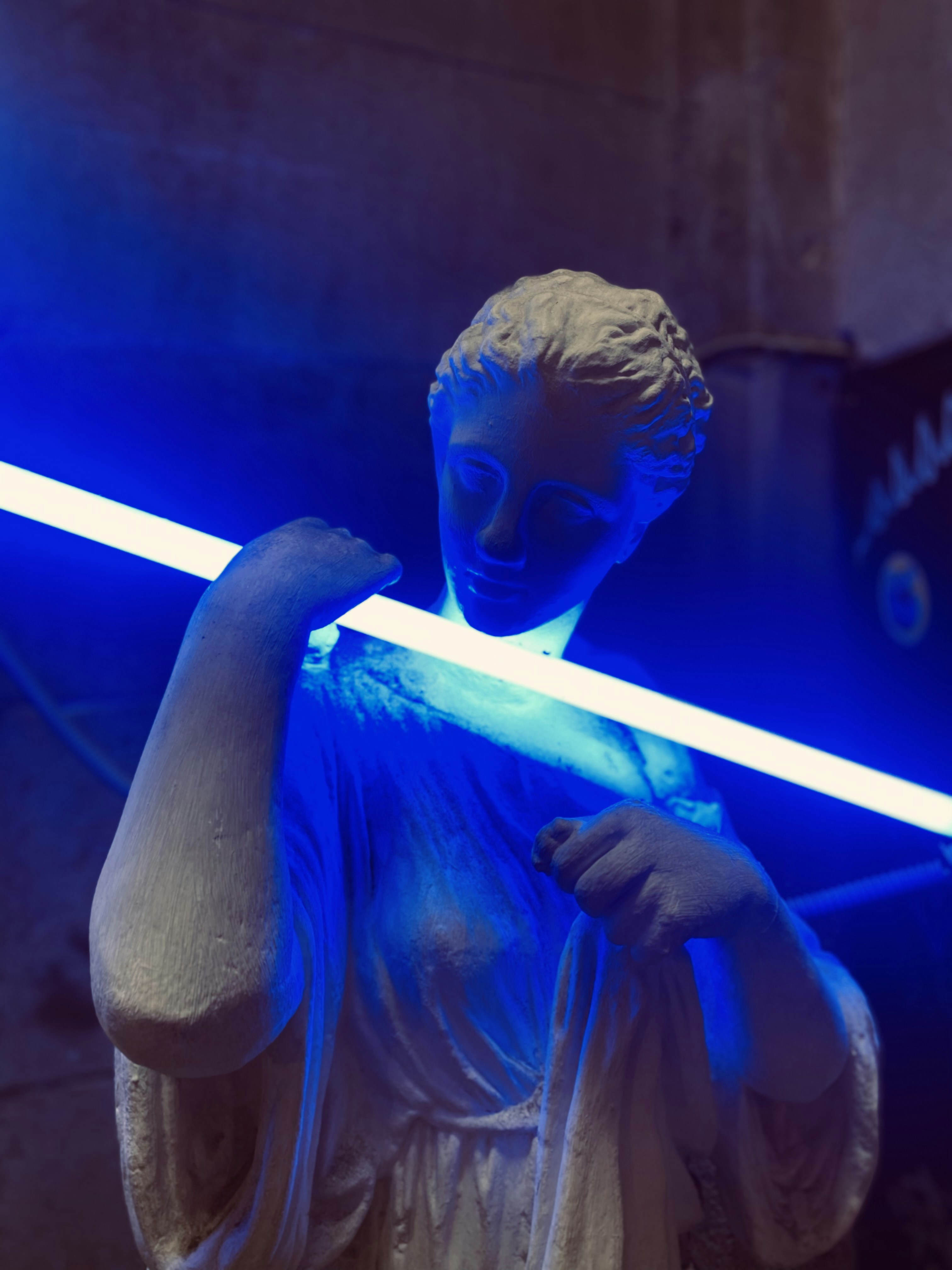 Cobalt Neon Across Marble: A Quiet Bust in Electric Light