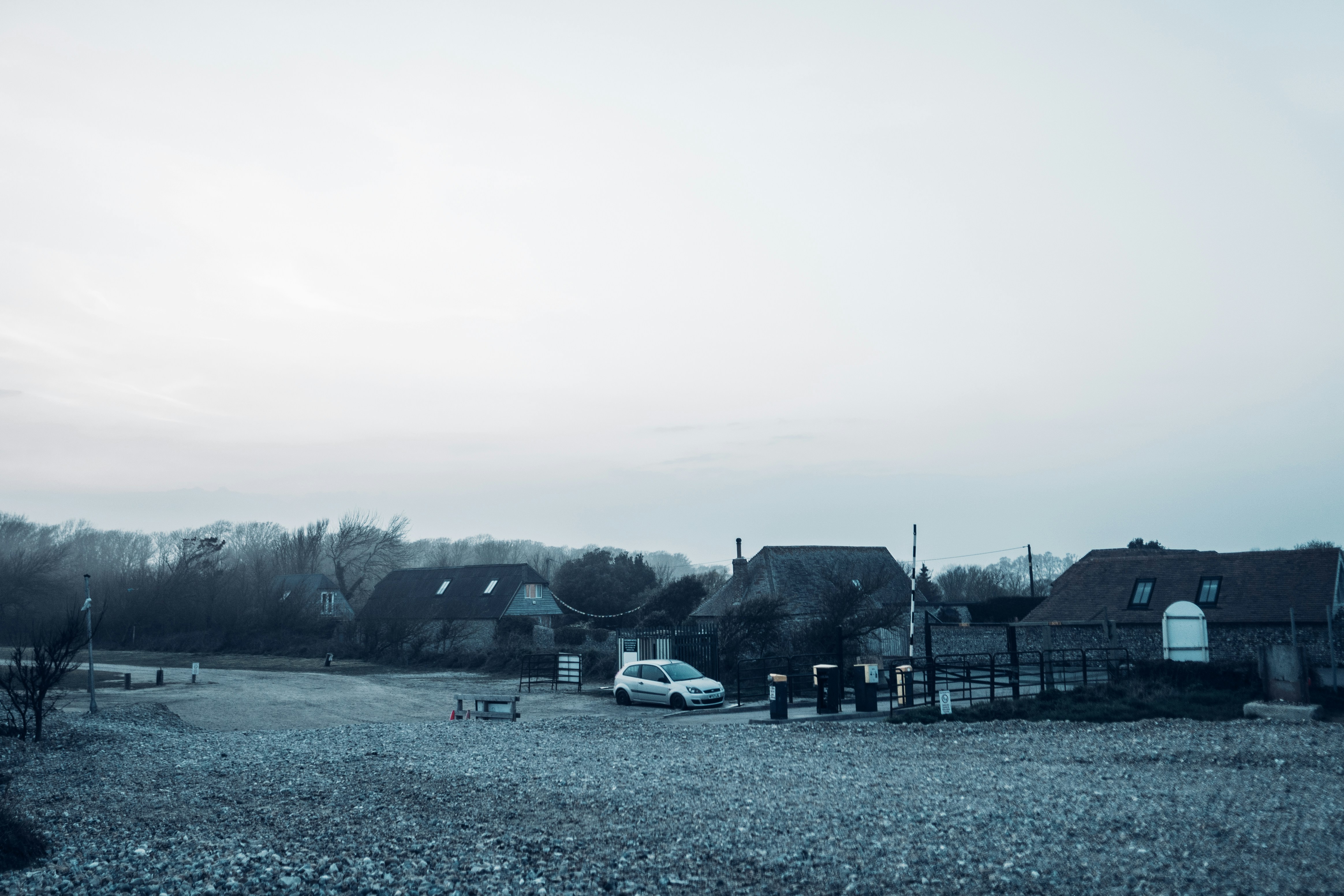 Dawn on the Pebble Street: A White Car Among Quiet Village Homes