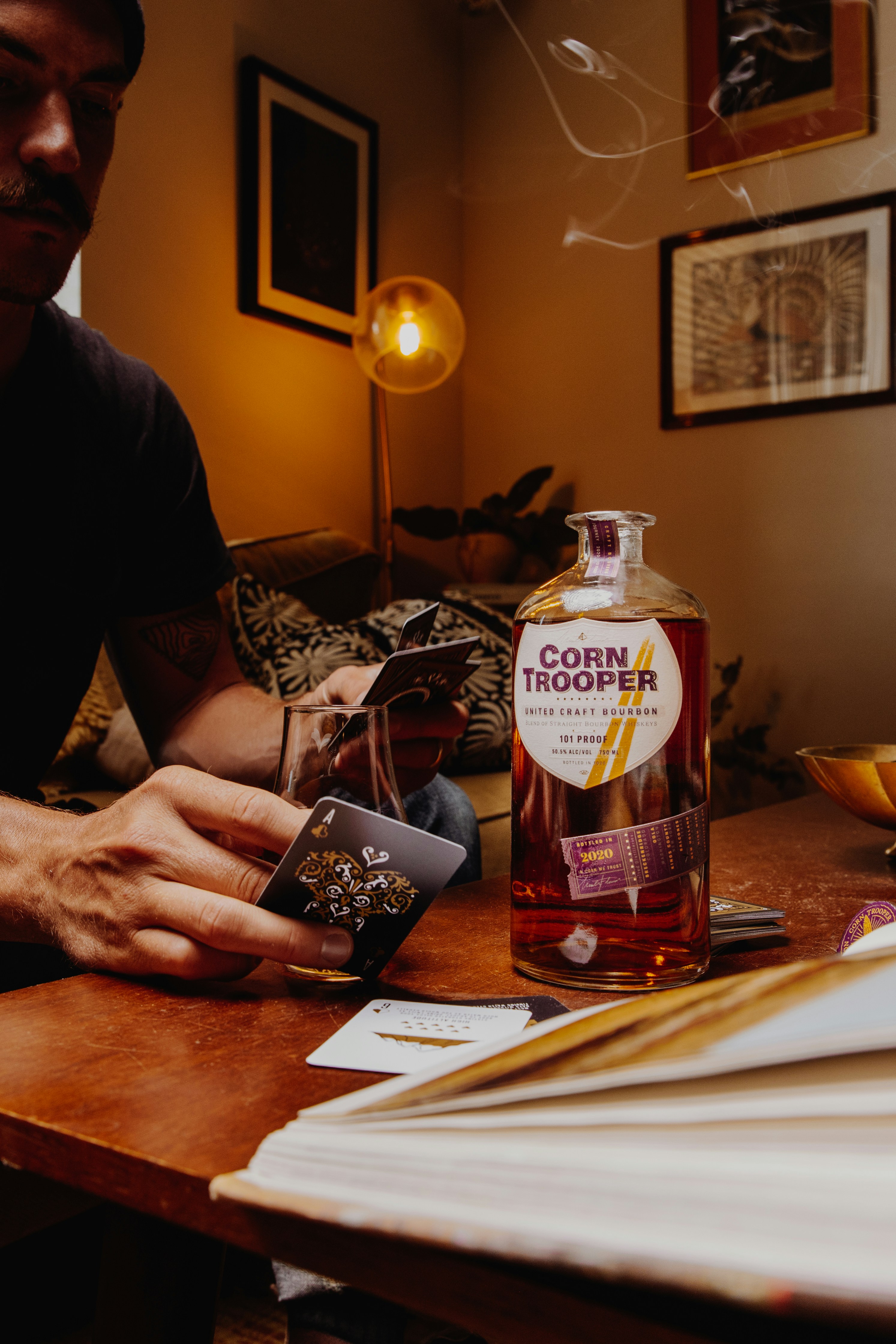 Amber Hourcard: Cards, Glass, and a Bottled Moment on a Living Room Table