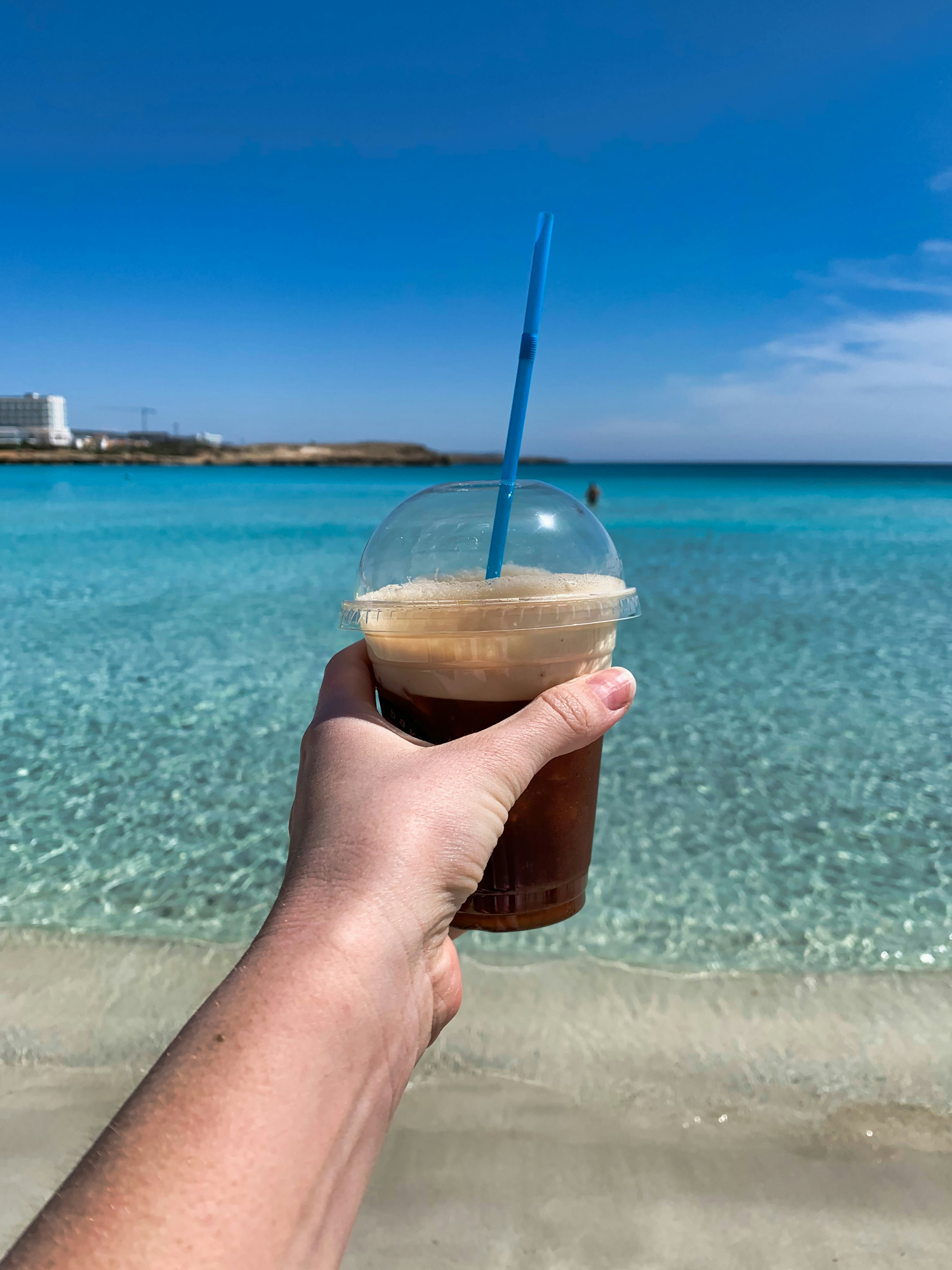 Caribbean Sip: Iced Coffee Framed by Clear Turquoise Waves
