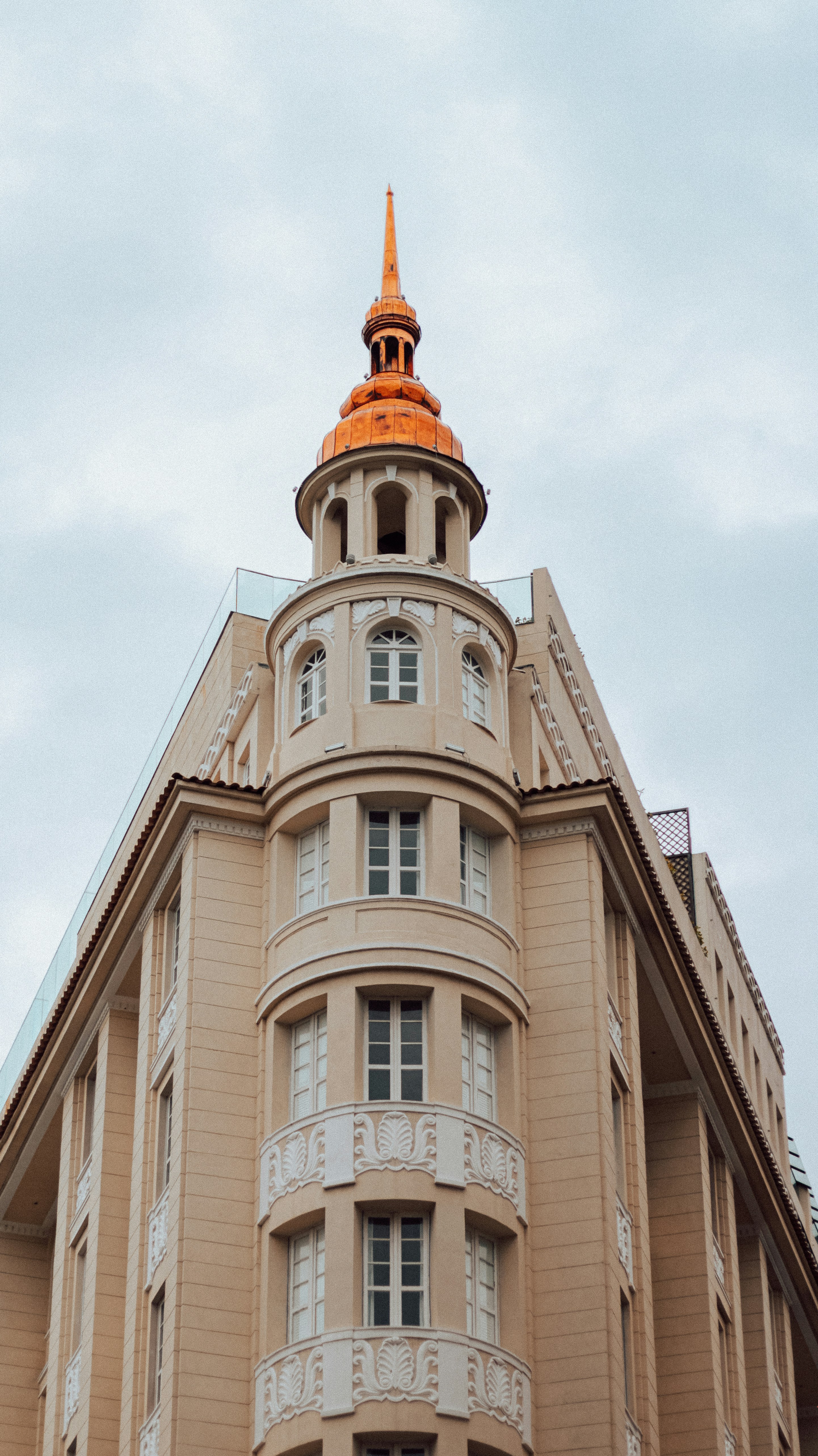Gold-tipped Spire Rising Over a Curved Art Deco Facade