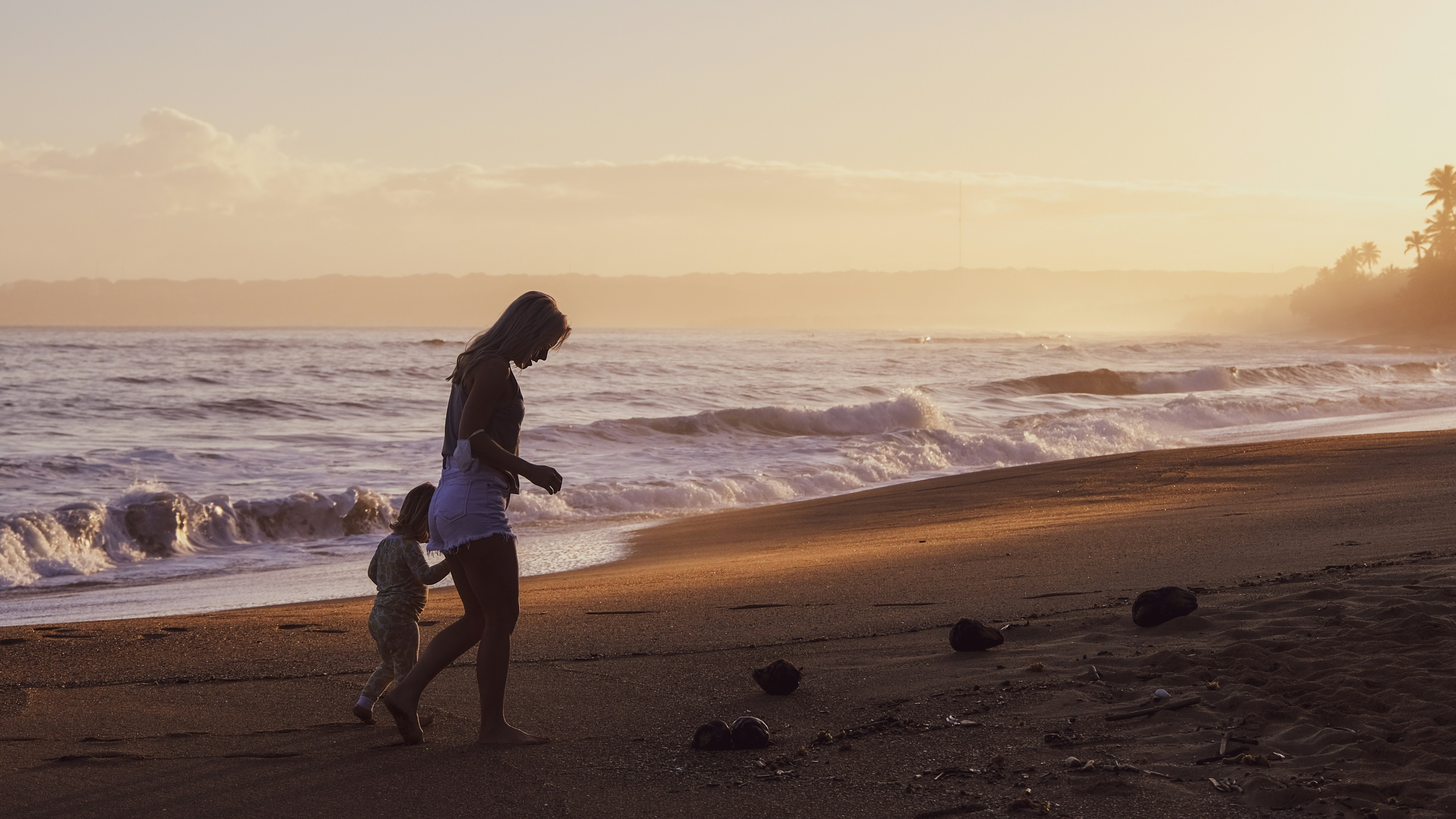 Man and woman walking on beach during sunset photo – Free Rincon Image on Unsplash