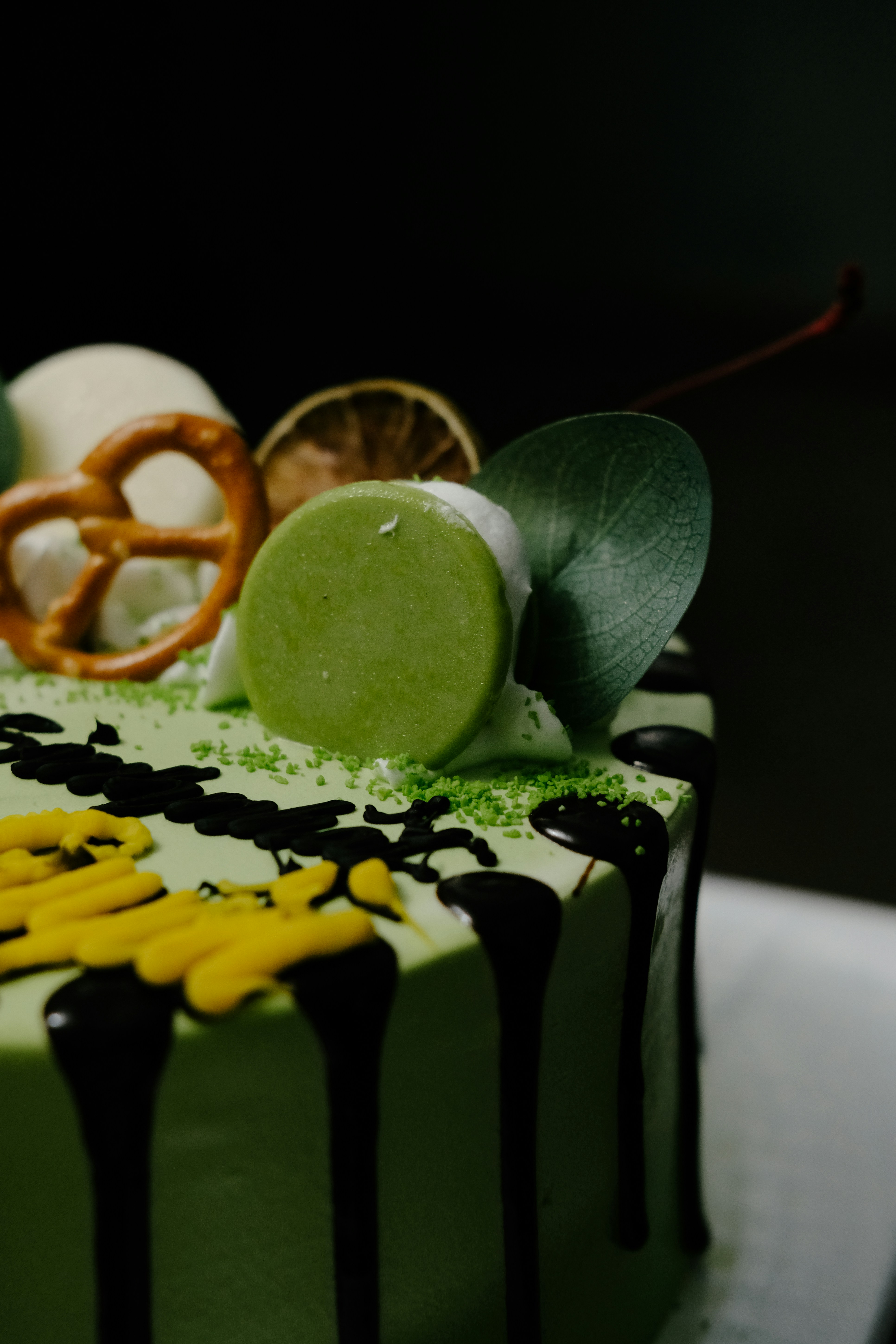 Verdant Macaron Reigning Over a Chocolate-Drip Cake