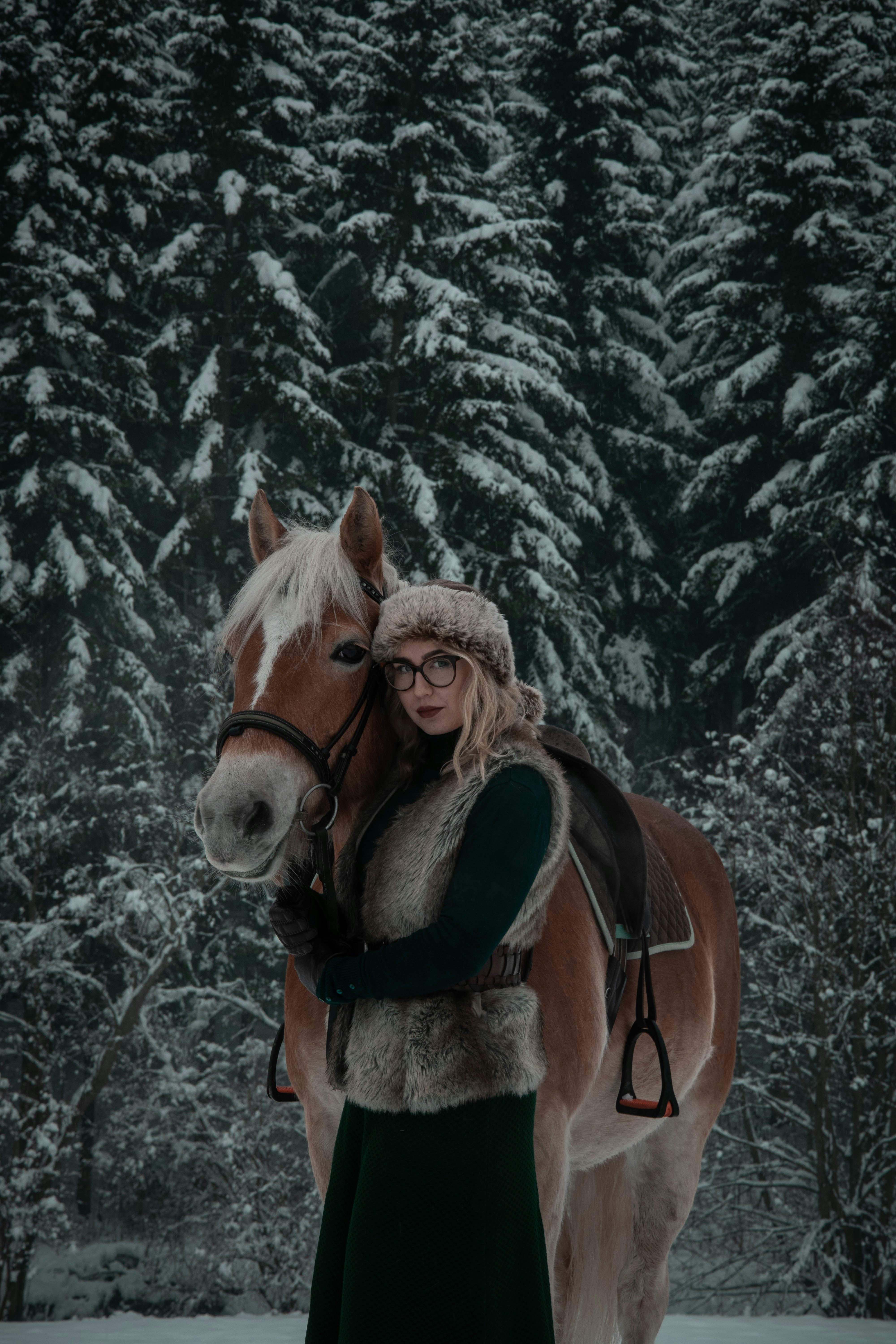 Winter Companions: A Woman and Horse Embrace in a Frosted Forest