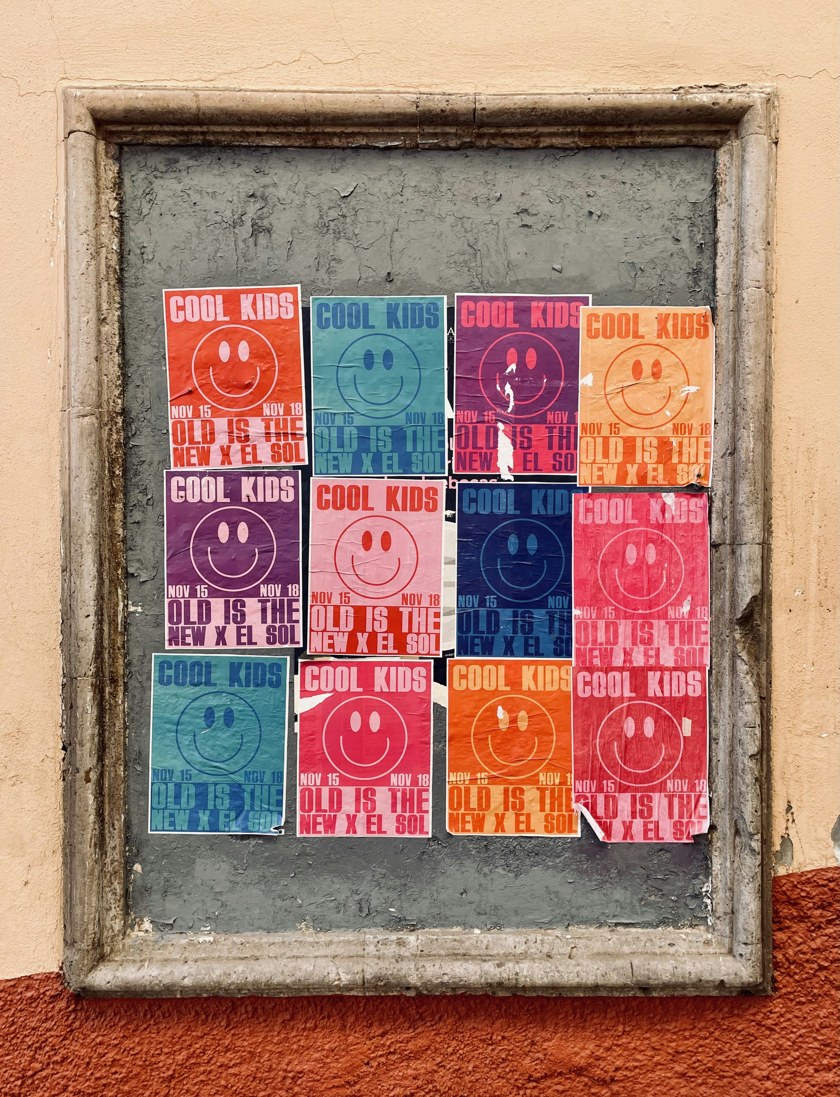 Colorful Stamp Grid: Repetitive 'Cool Kids' Posters on a Window Pane