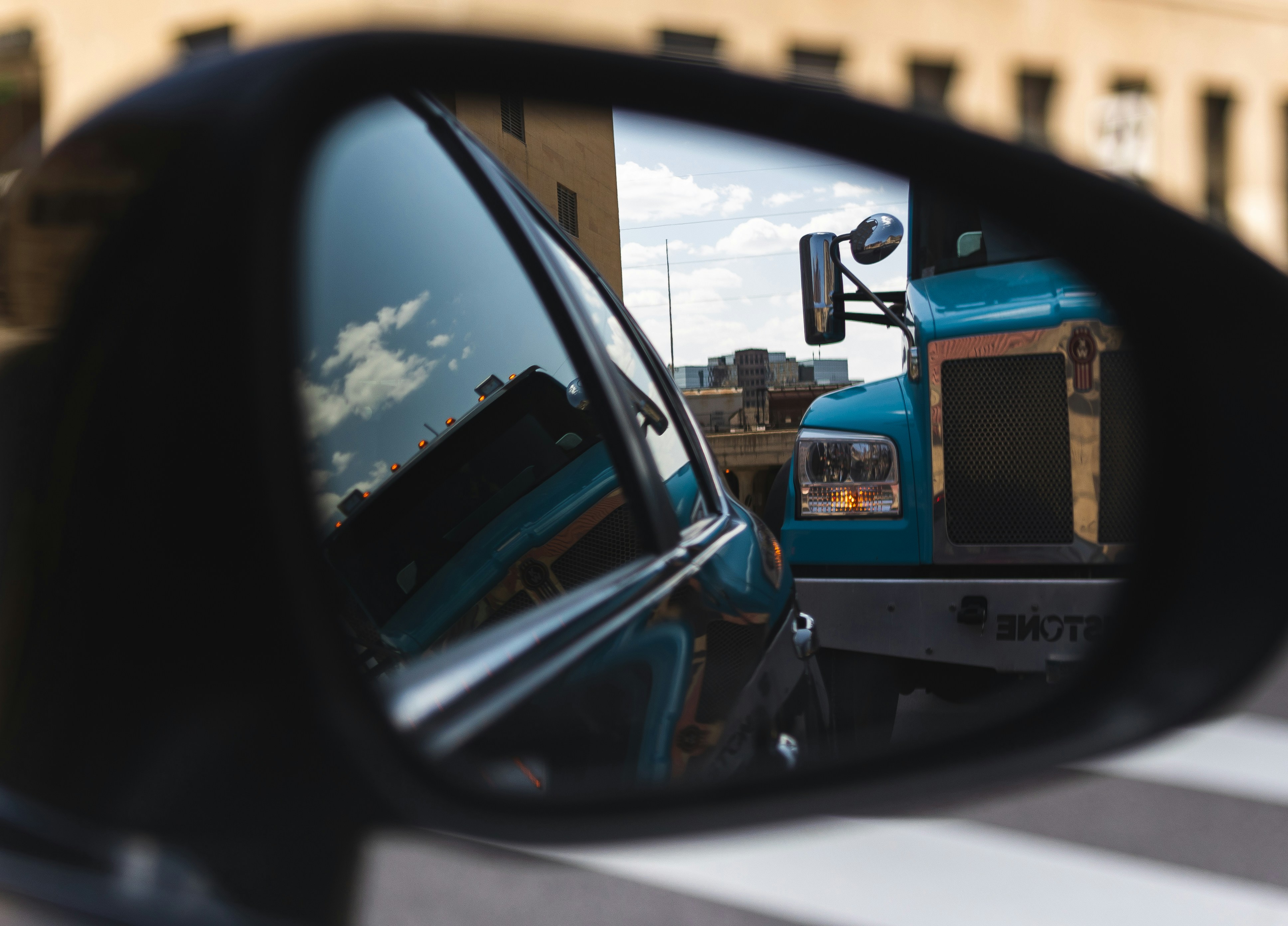 Reflected Turquoise: Truck Front Framed in a City Side Mirror