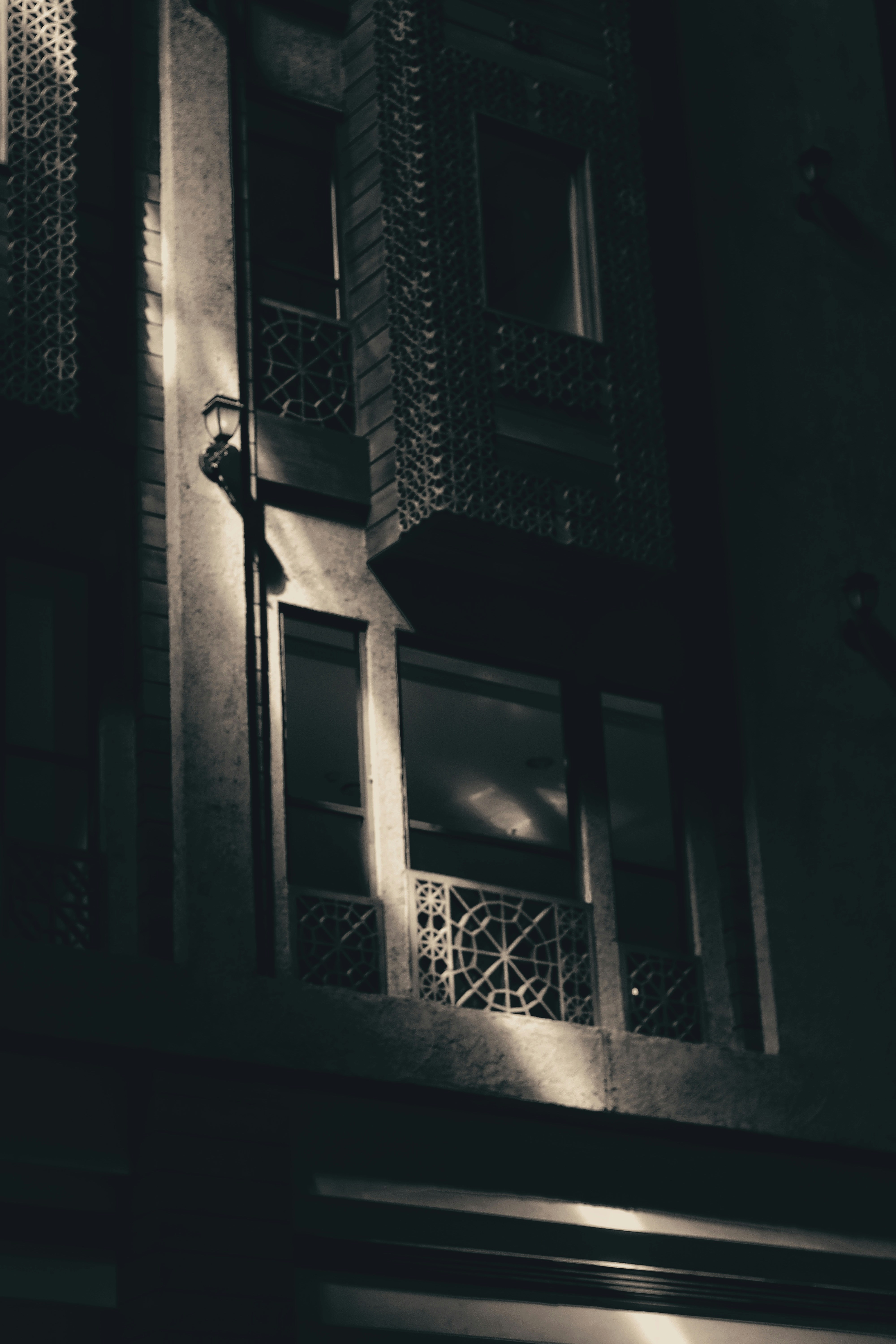 Night ascent: a lone climber clings to a dimly lit urban facade