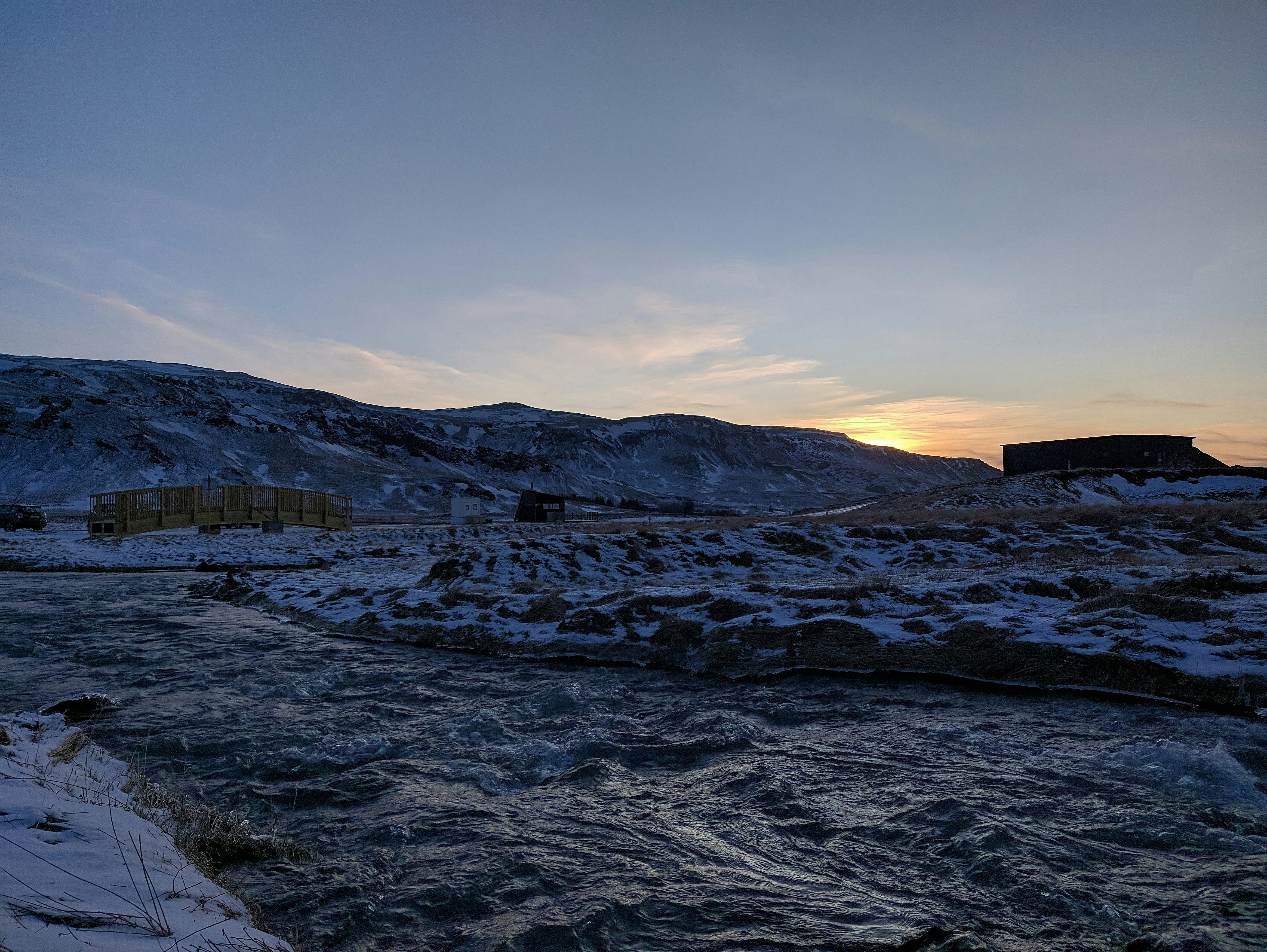 Sunset Over the Snow-Scored River: Distant Huts and Quiet Hills