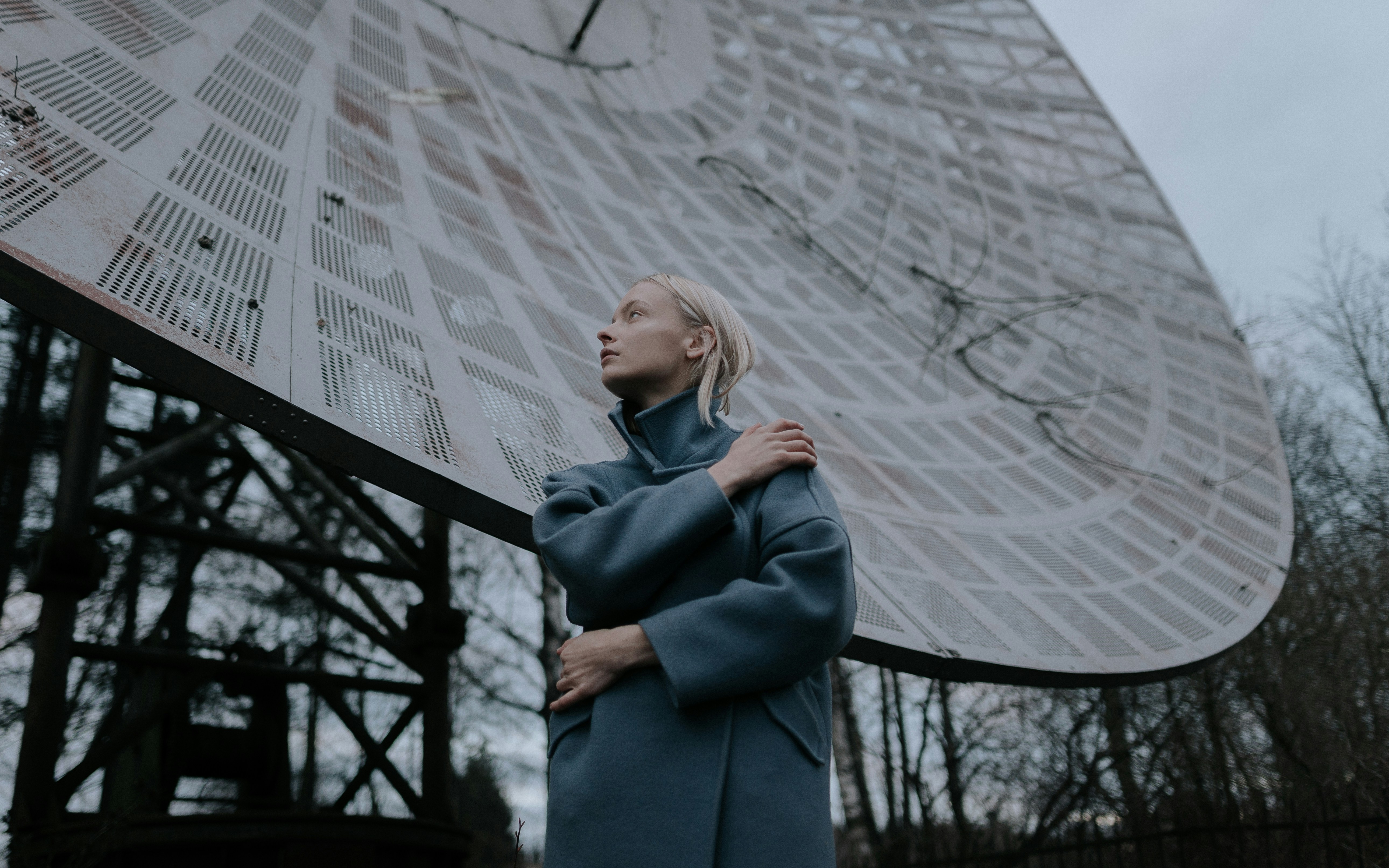 Portrait Under a Megastructure: A Quiet Moment Beneath the Weave of Steel and Sky