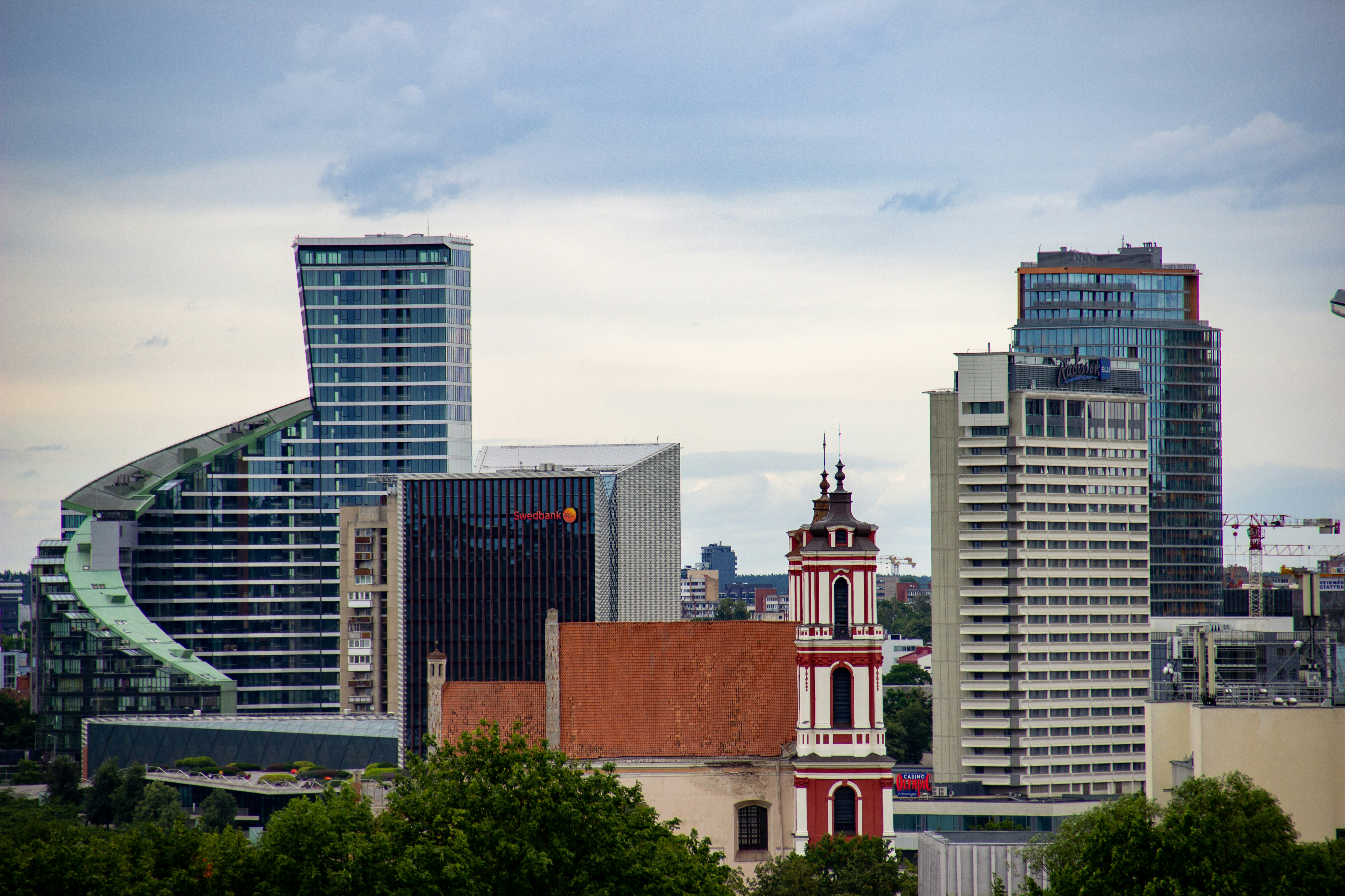 Skyline featuring diverse architectural styles under a cloud-dappled sky.
