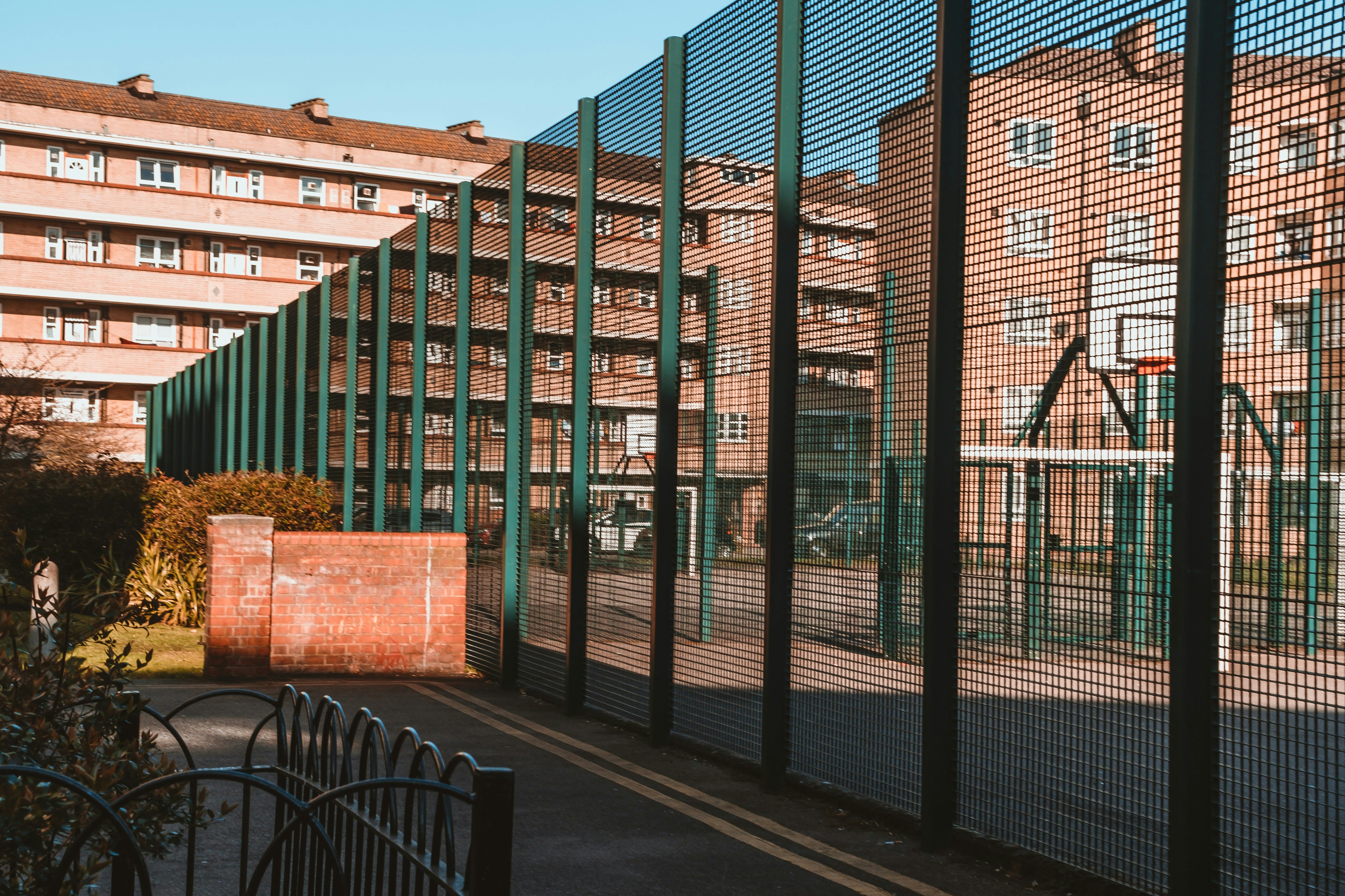 black metal fence near brown brick wall building during daytime
