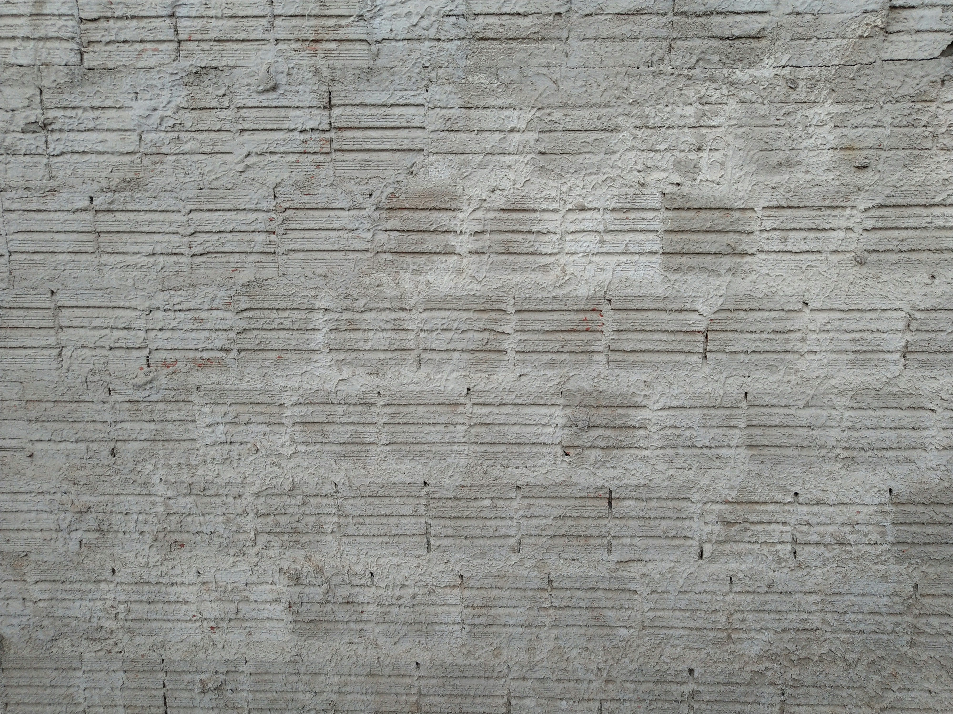 Close-up view of a weathered concrete wall with distinct horizontal lines and subtle variations in texture.