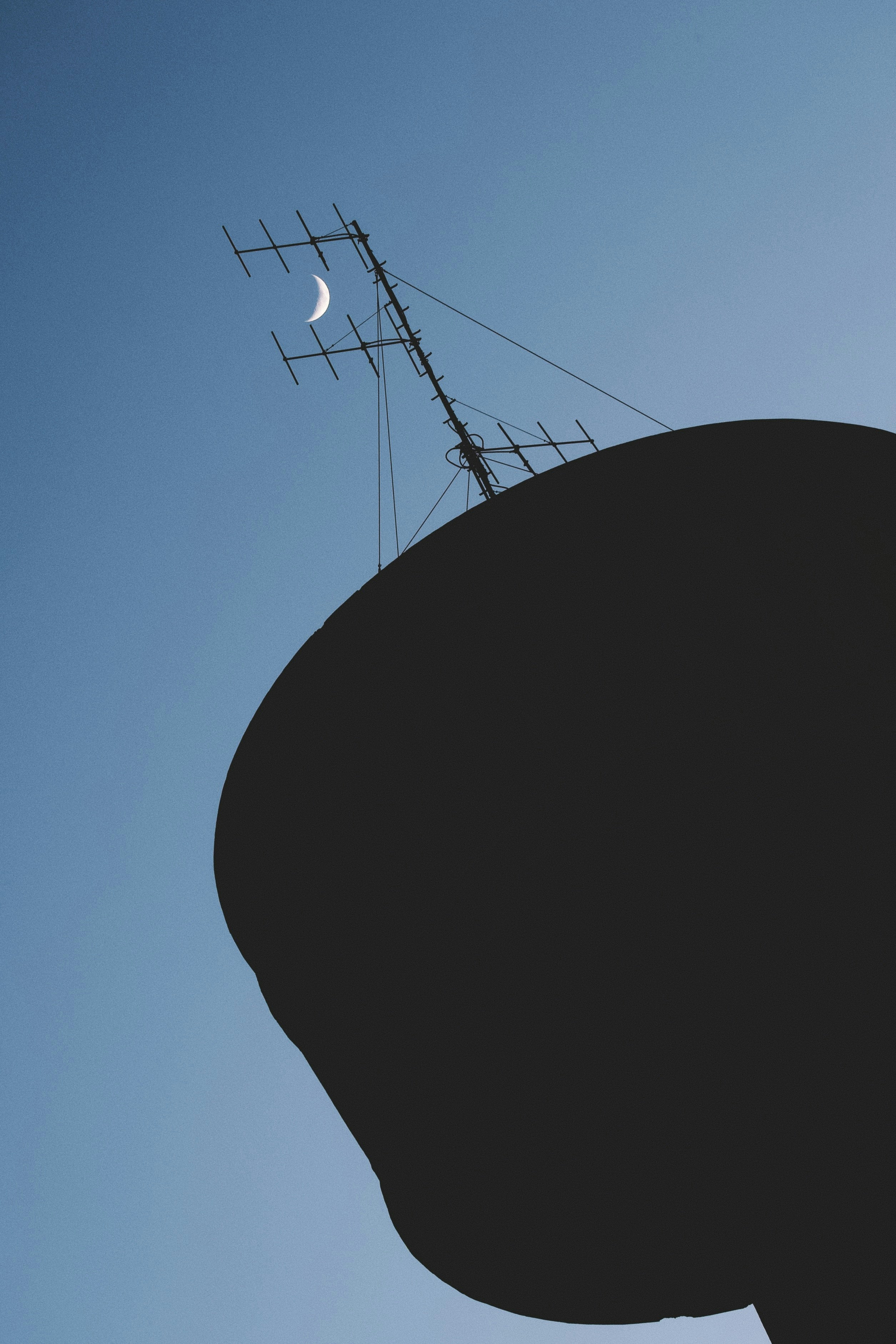 Moonlit Antenna Over a Silhouette of a Satellite Dish