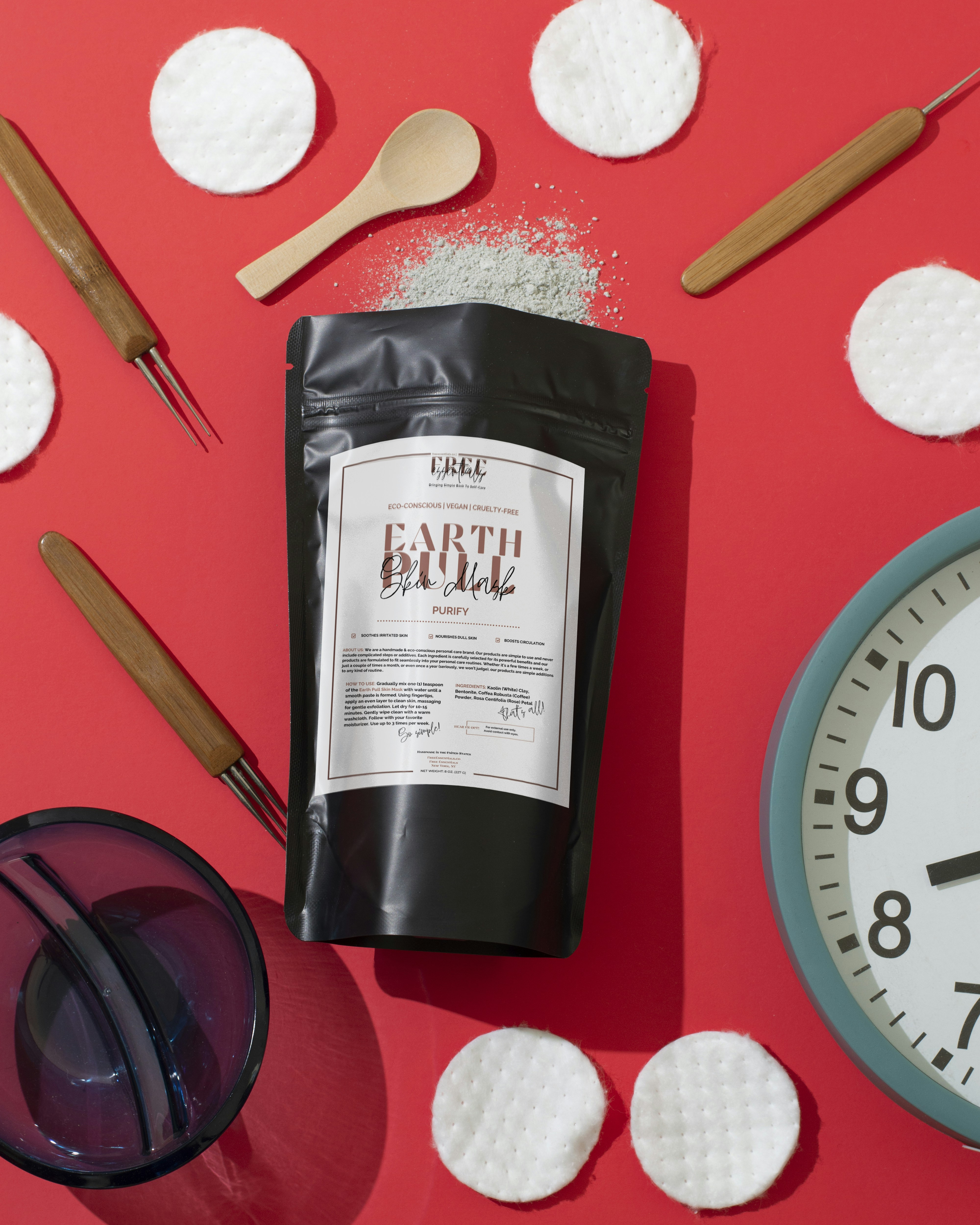 A black packaging of 'Earth' blend sits at the center, surrounded by kitchen tools and cotton pads on a vibrant red backdrop.