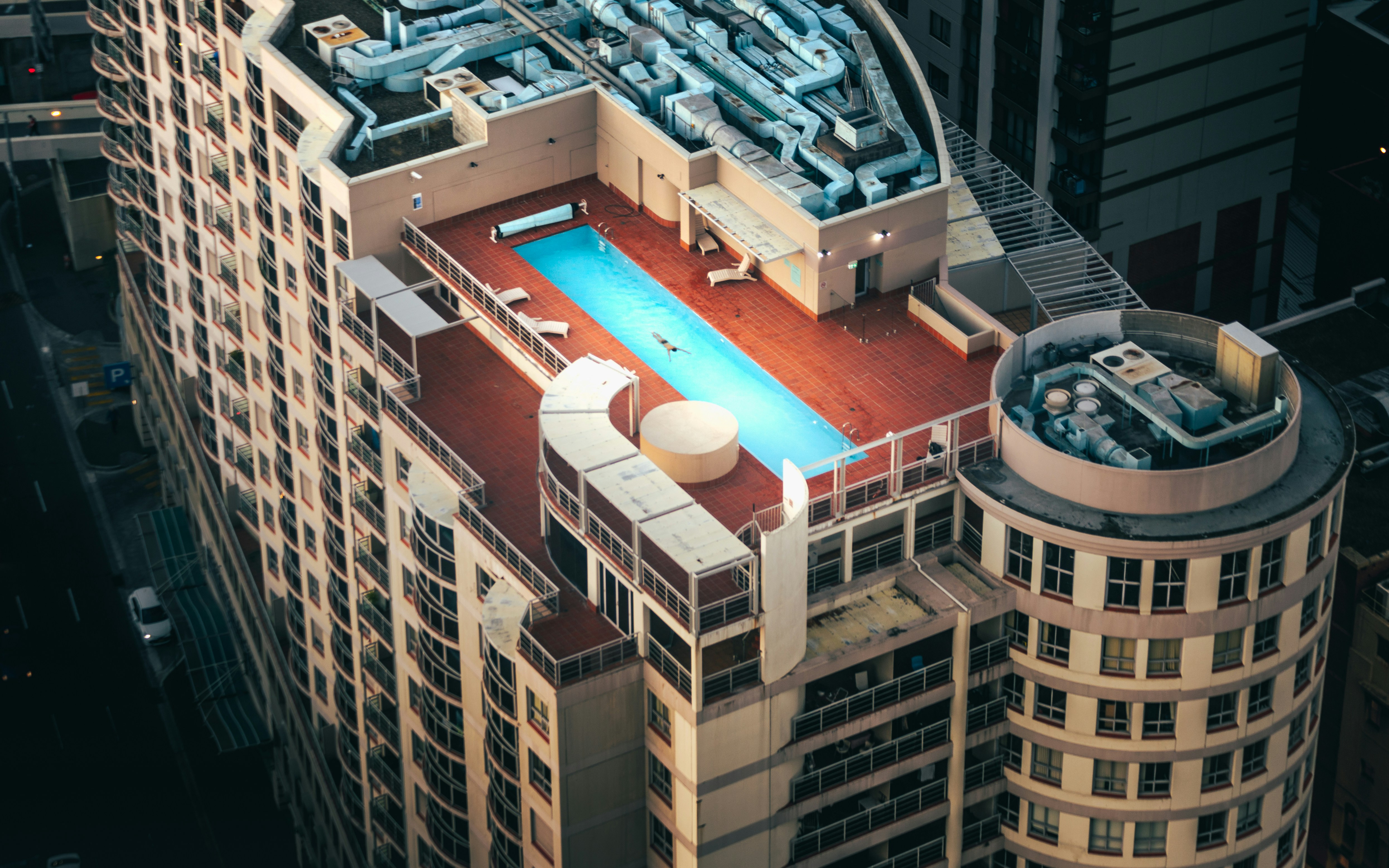 Aerial view of a rooftop pool surrounded by modern architecture, showcasing a serene escape in the heart of the city.