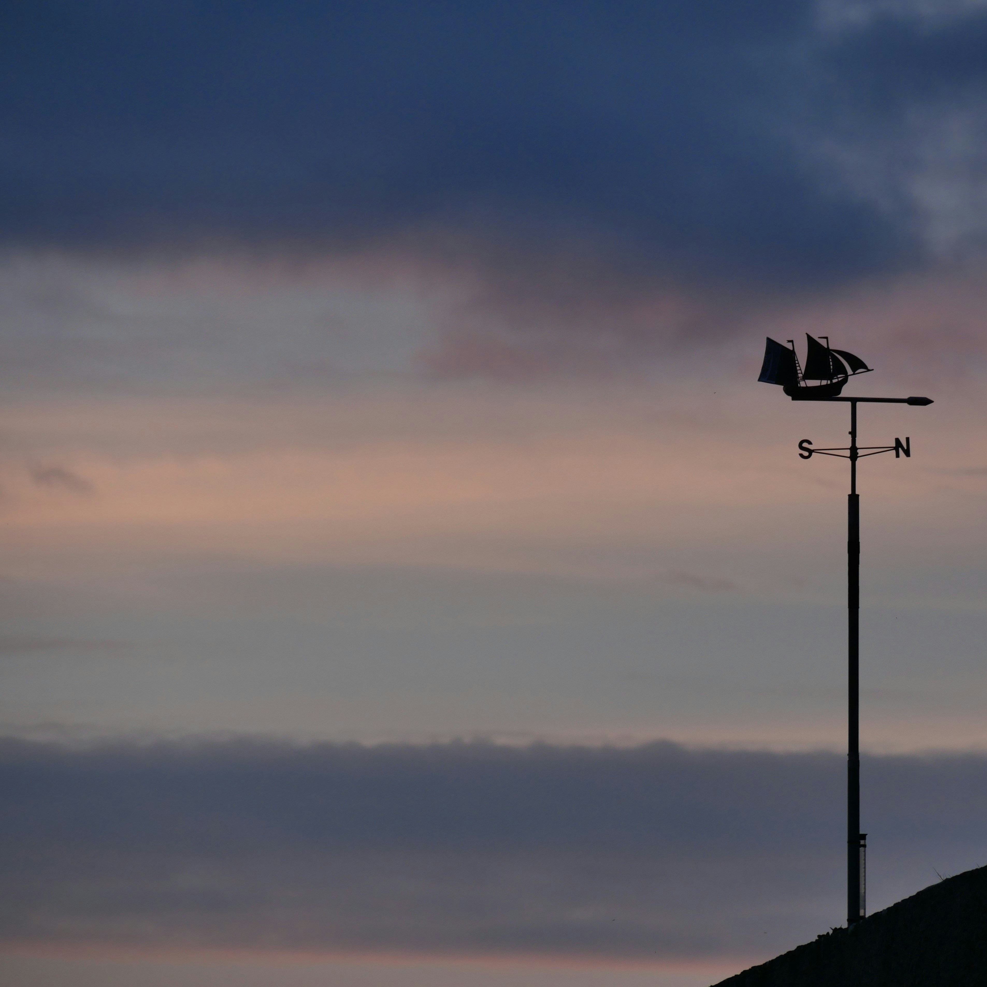 Silhouette of a Weather Vane Against a Pale Dusk Sky