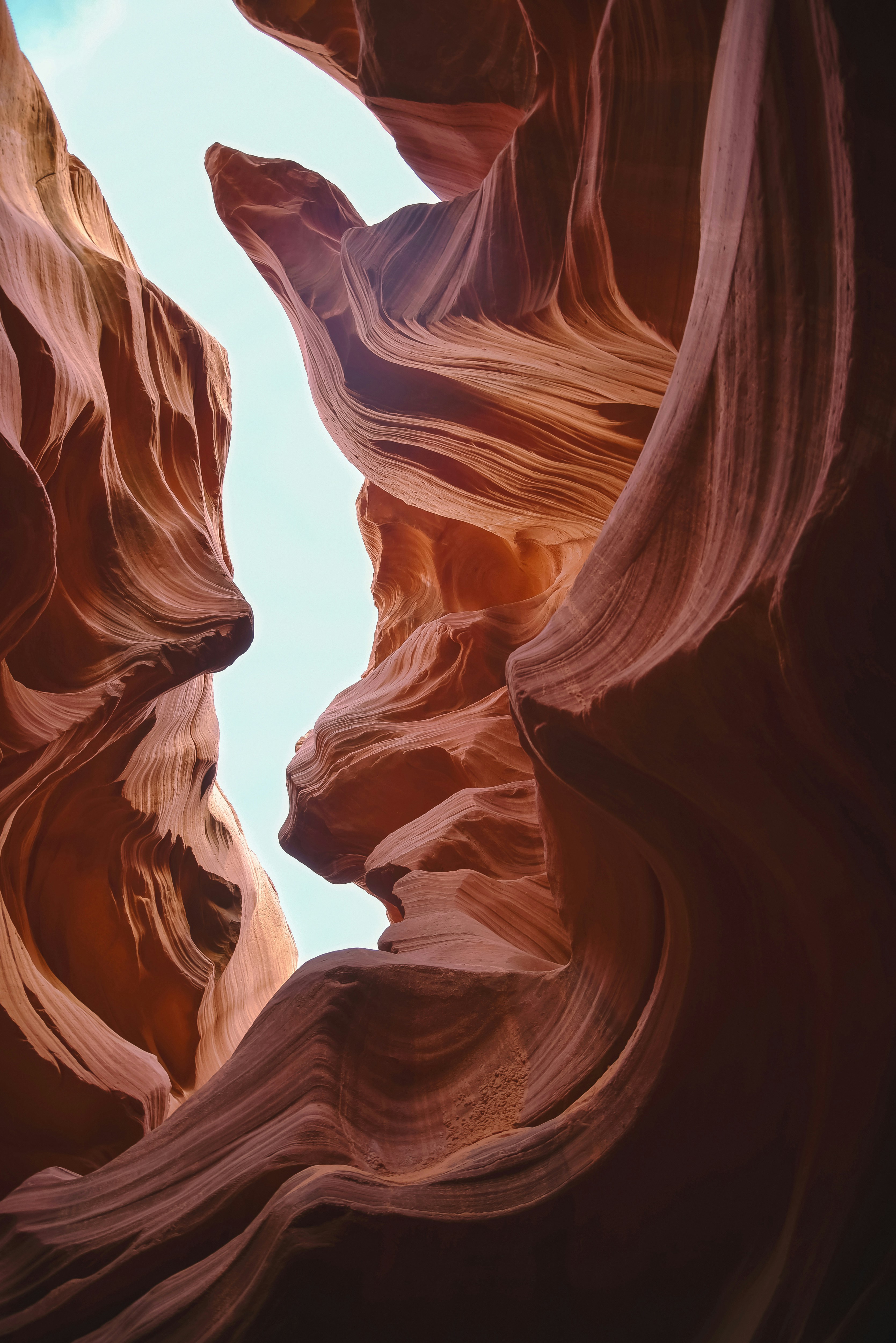 Intricate sandstone formations rise dramatically, creating a natural corridor illuminated by soft light from above.