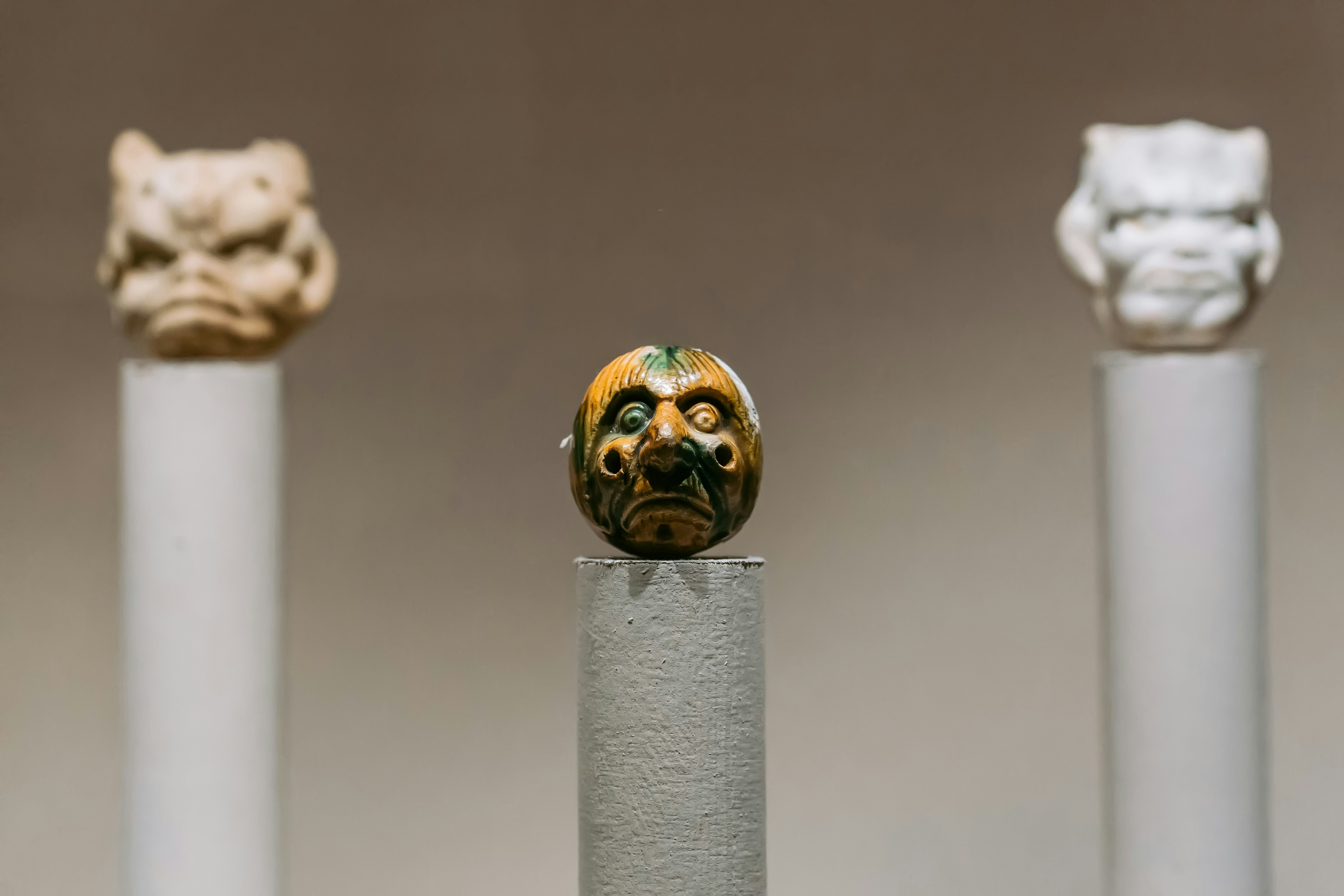Centerpiece Gaze: A Painted Head Among Silent Pedestal Guardians
